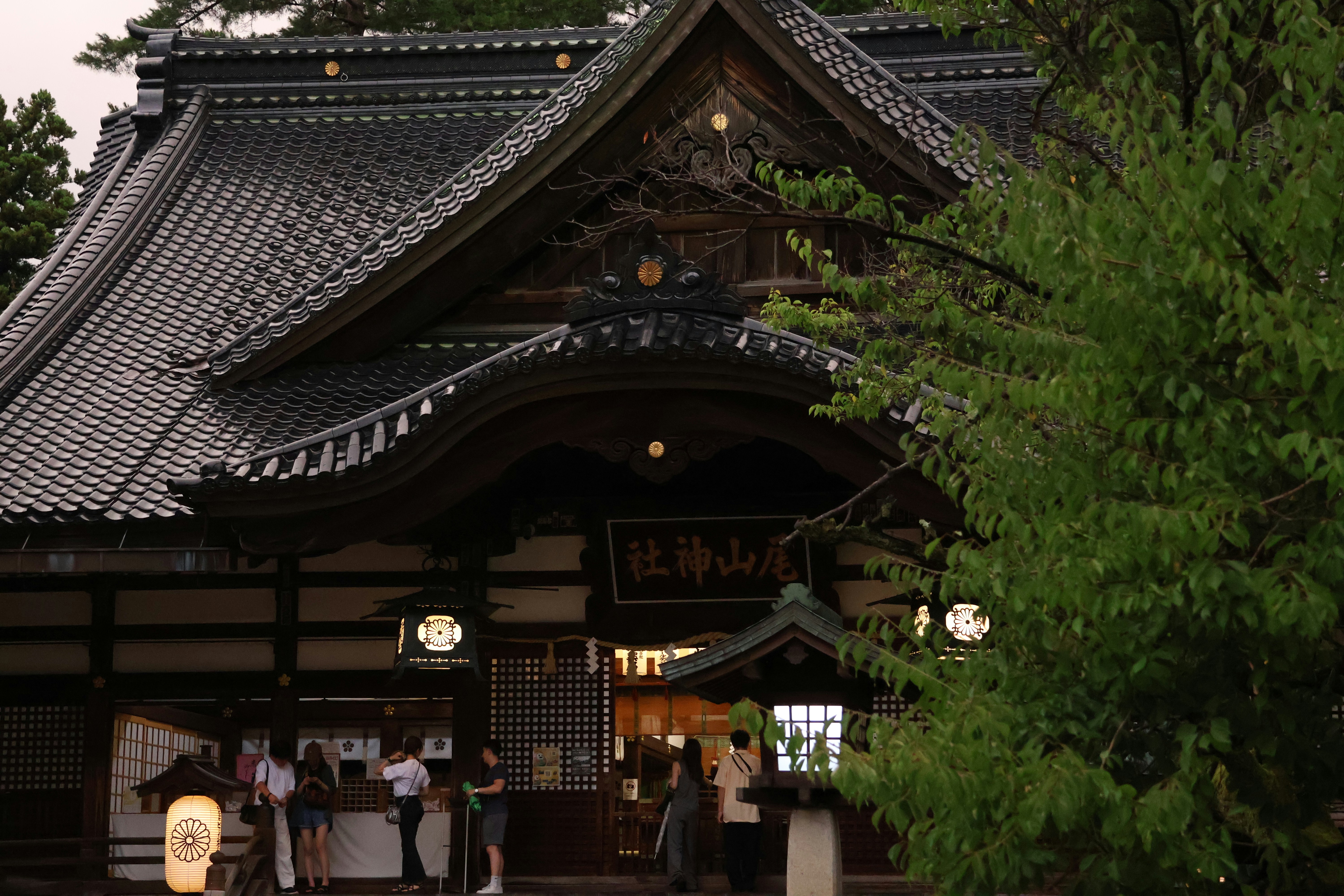 Temple Gates at Dusk: Lanterns Glow Beneath Curved Roofs