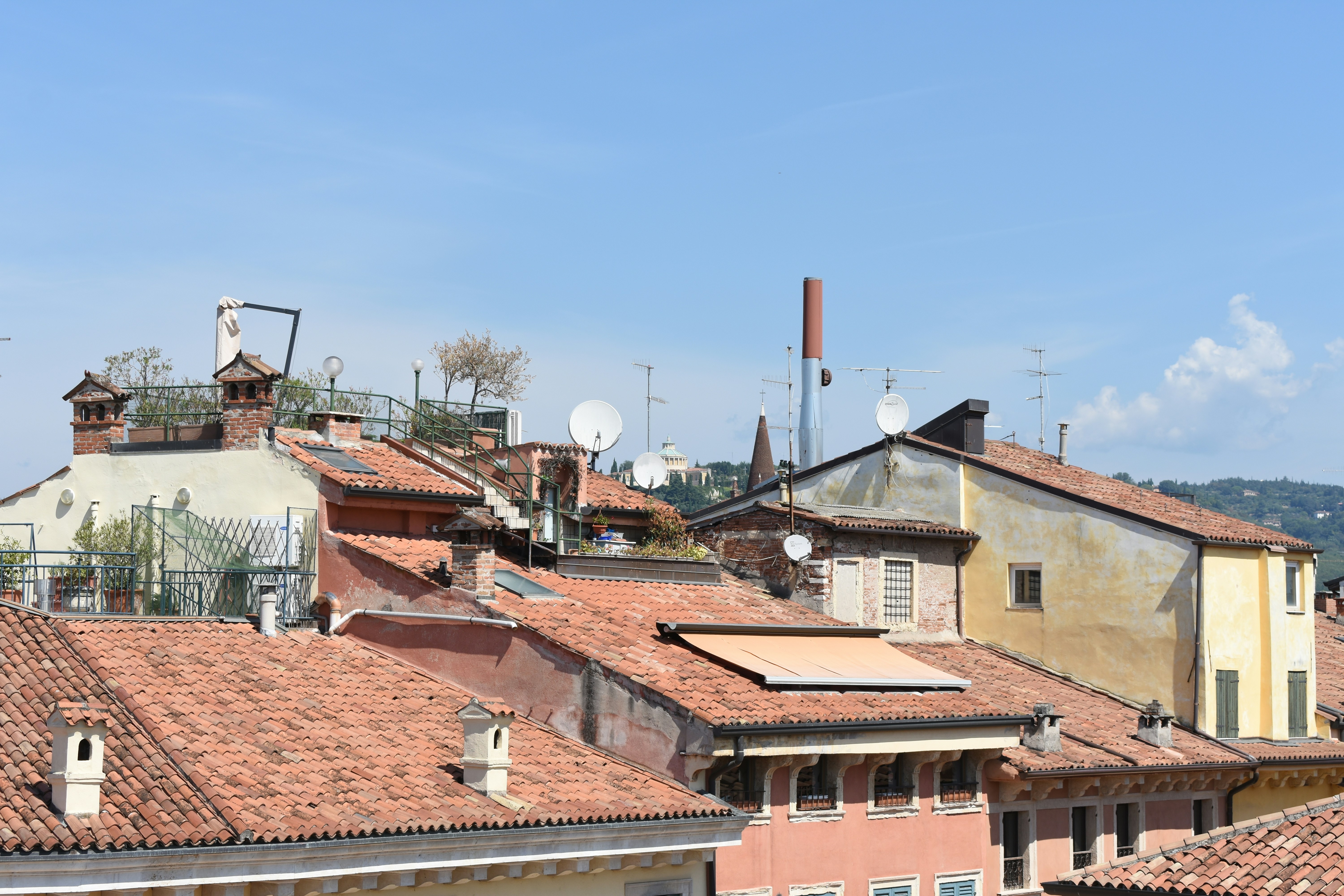Rooftop Mosaic: Sunlit Tiles and Antennas Across a Quiet European Panorama