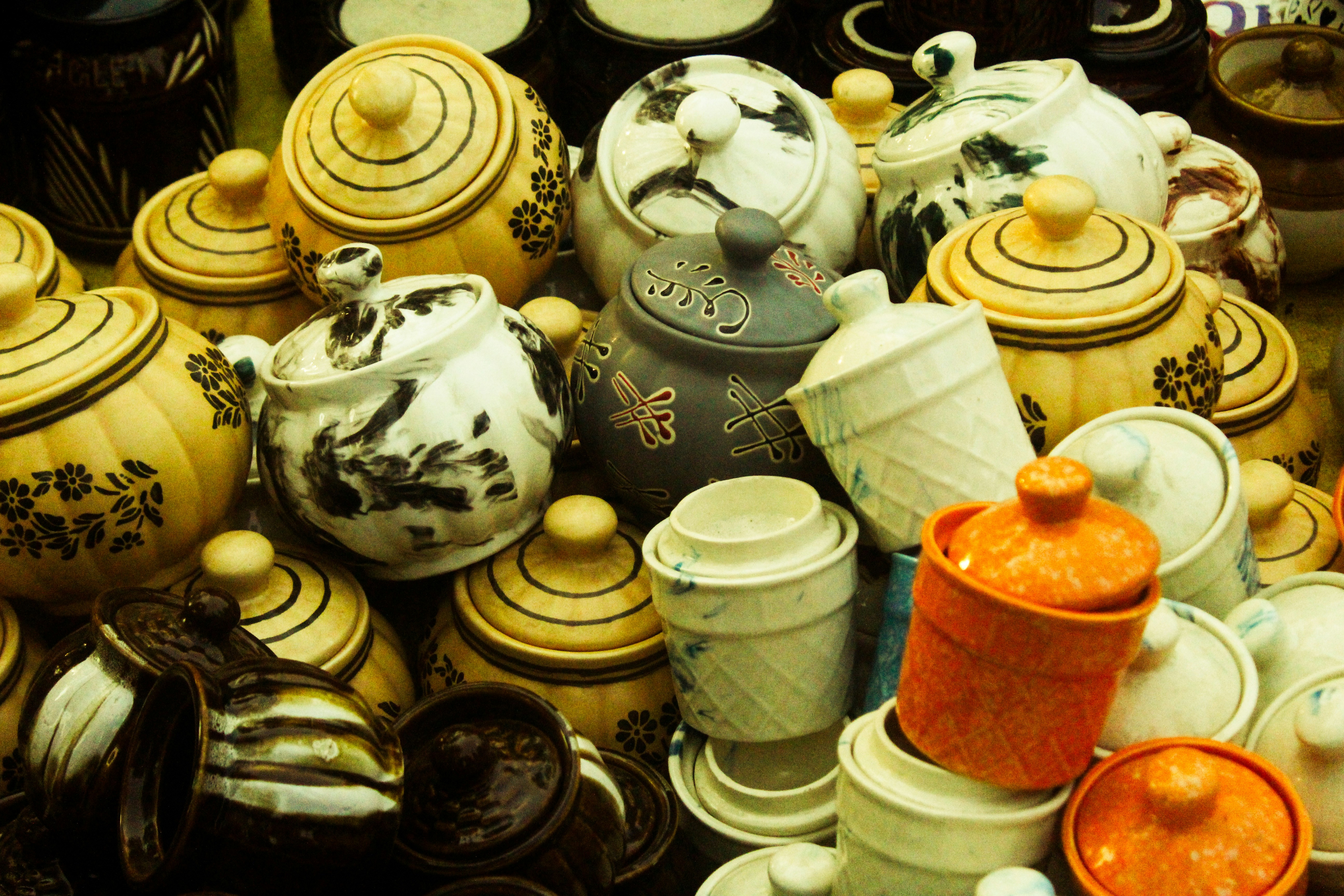 A mosaic of ceramic pots and teapots: color, glaze and pattern collide