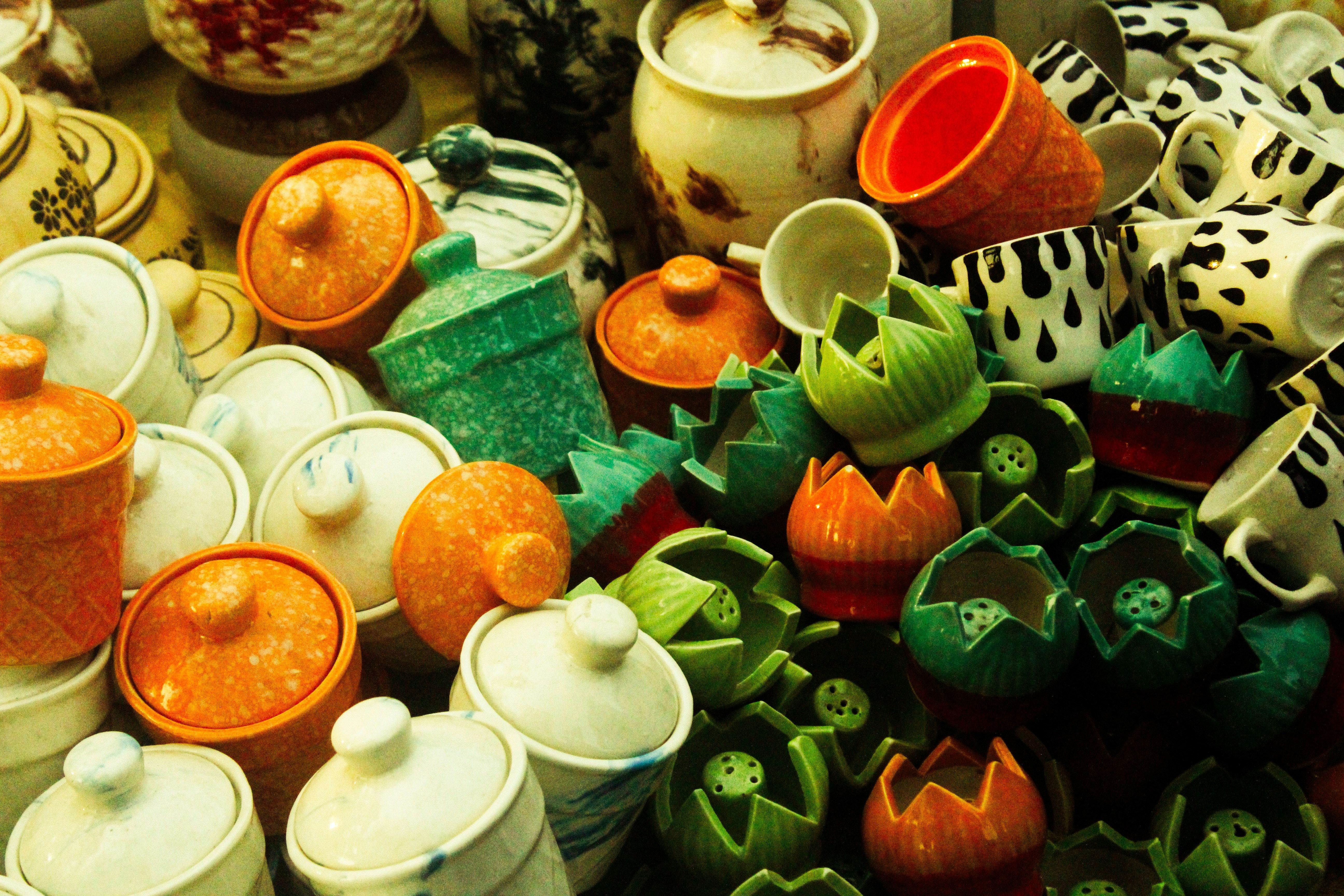 Colorful Ceramic Stacks: A Tumble of Lidded Pots and Floral Buds