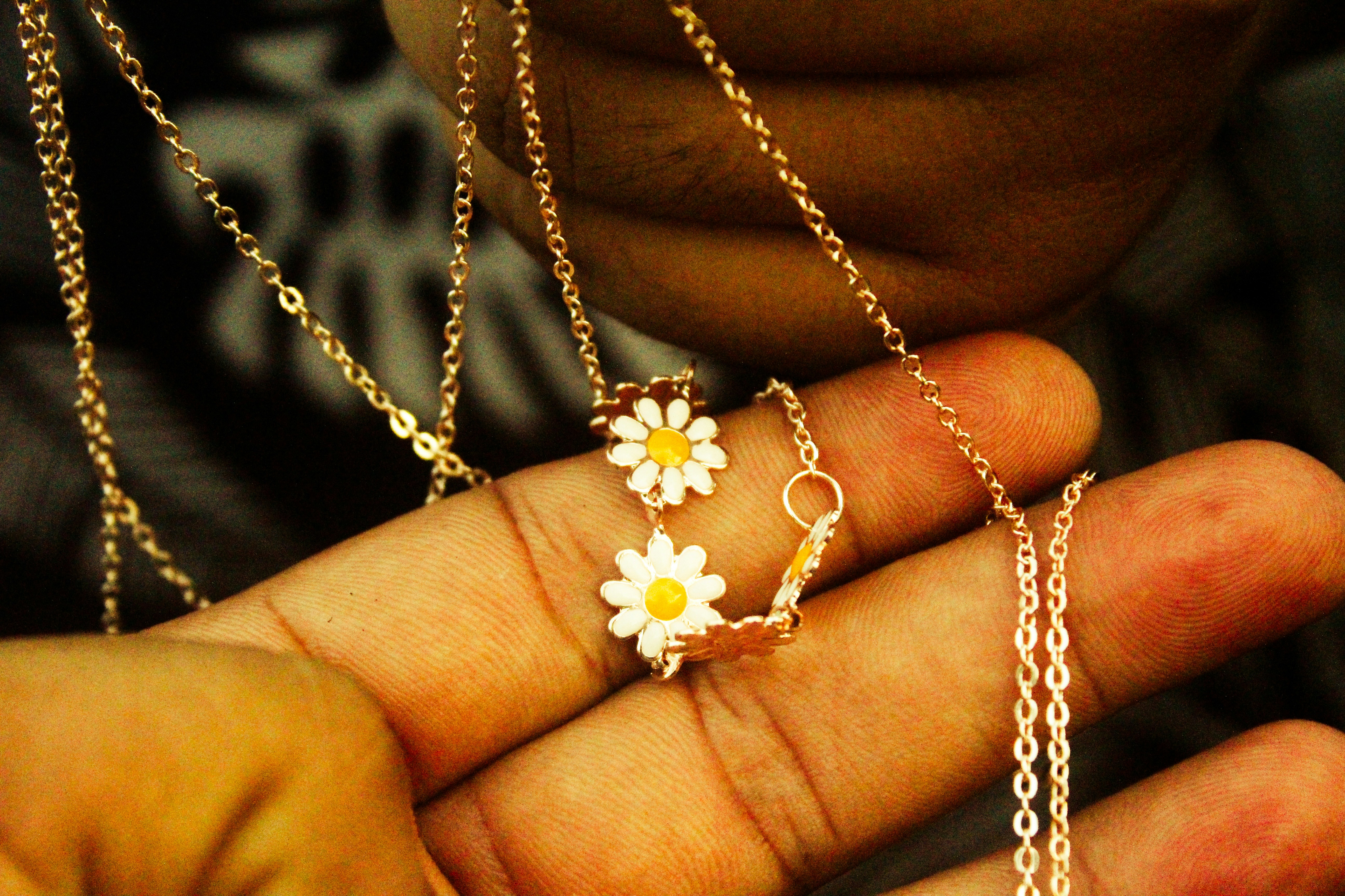 Dainty Daisy Necklace Delicately Resting Between Fingers