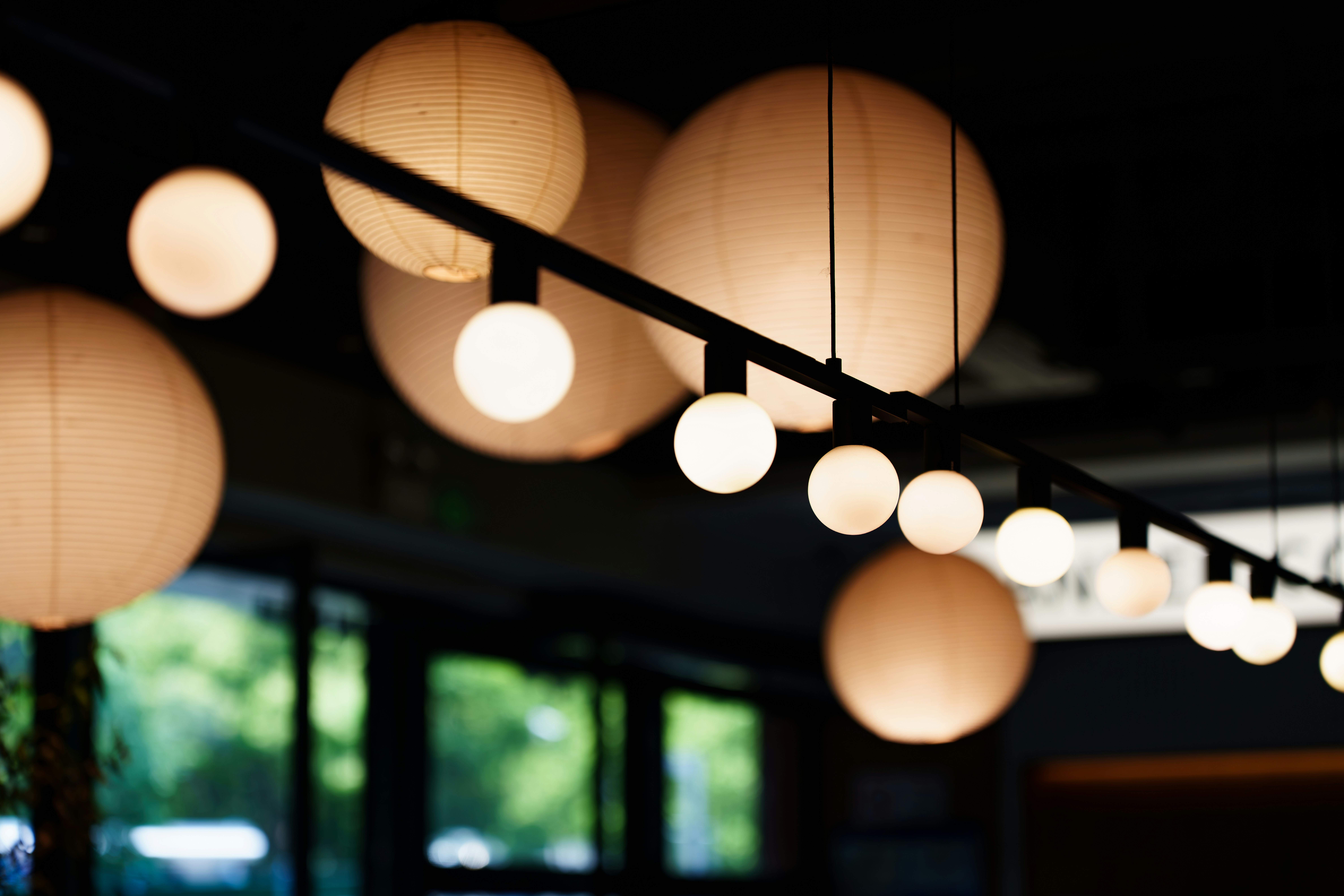 Soft orbs over a quiet cafe: ambient light and string of lanterns