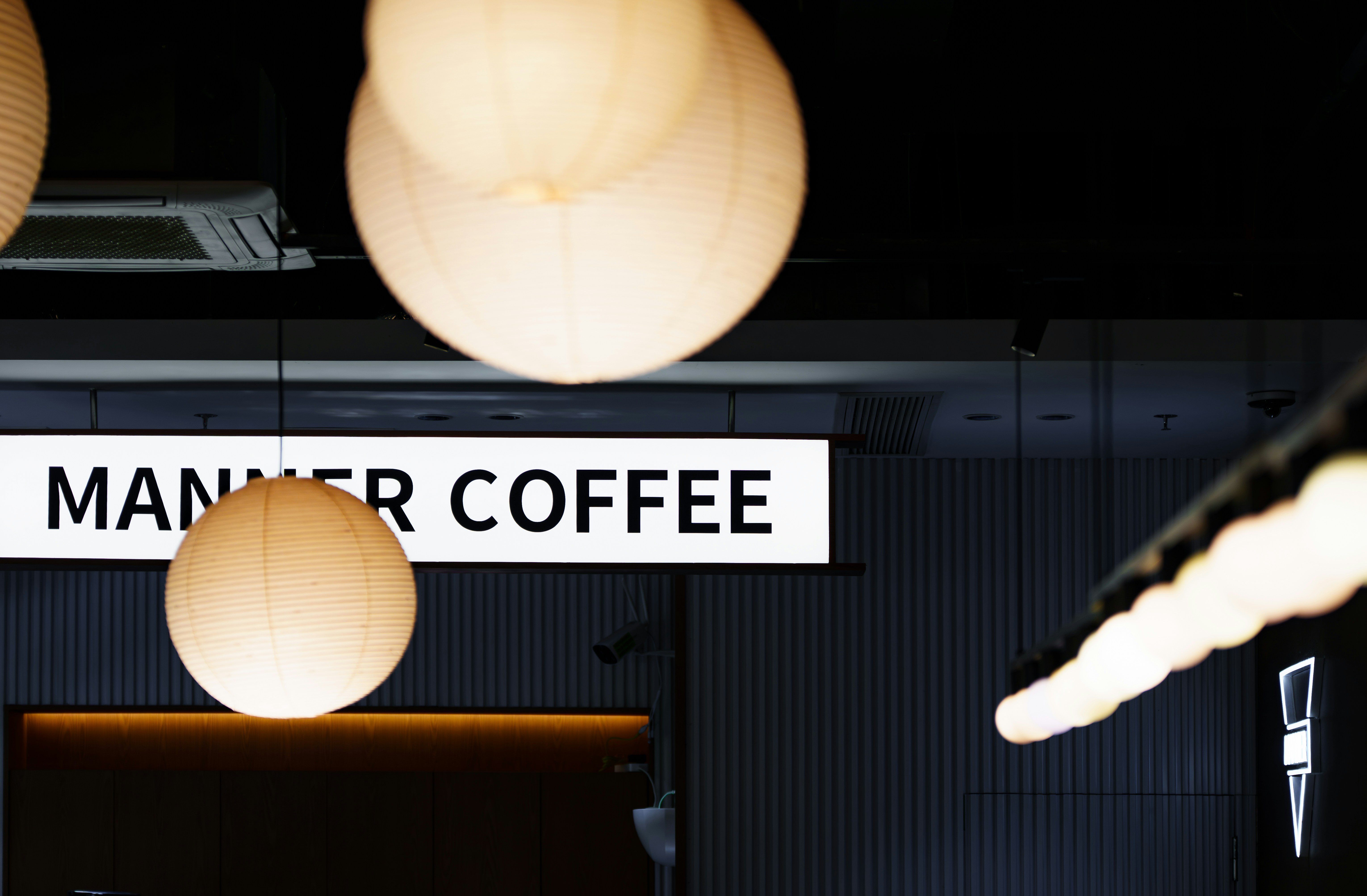 Neon Sign and Lanterns Over a Minimalist Coffee Bar