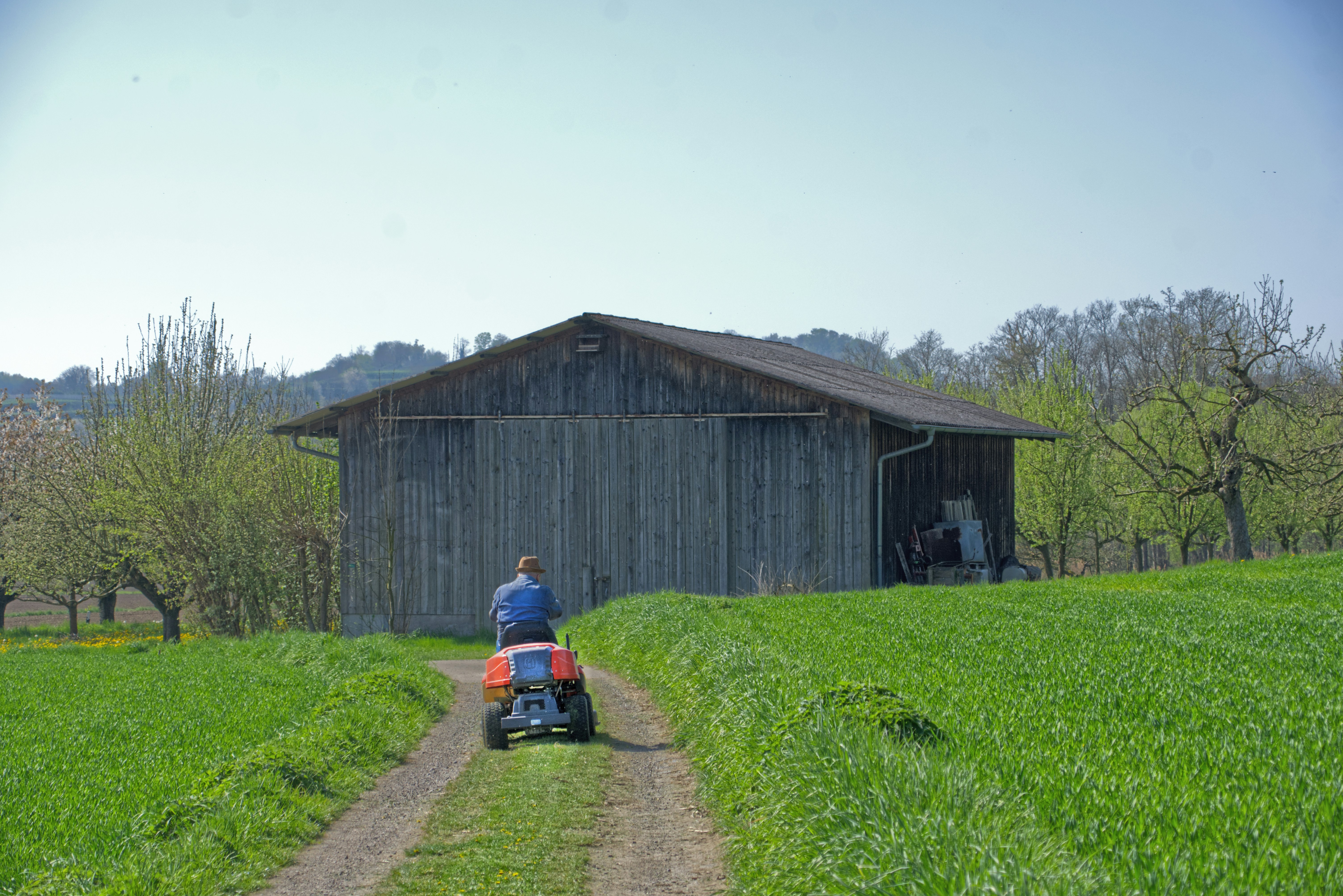 Rural Ride: A rider on a path toward a weathered barn