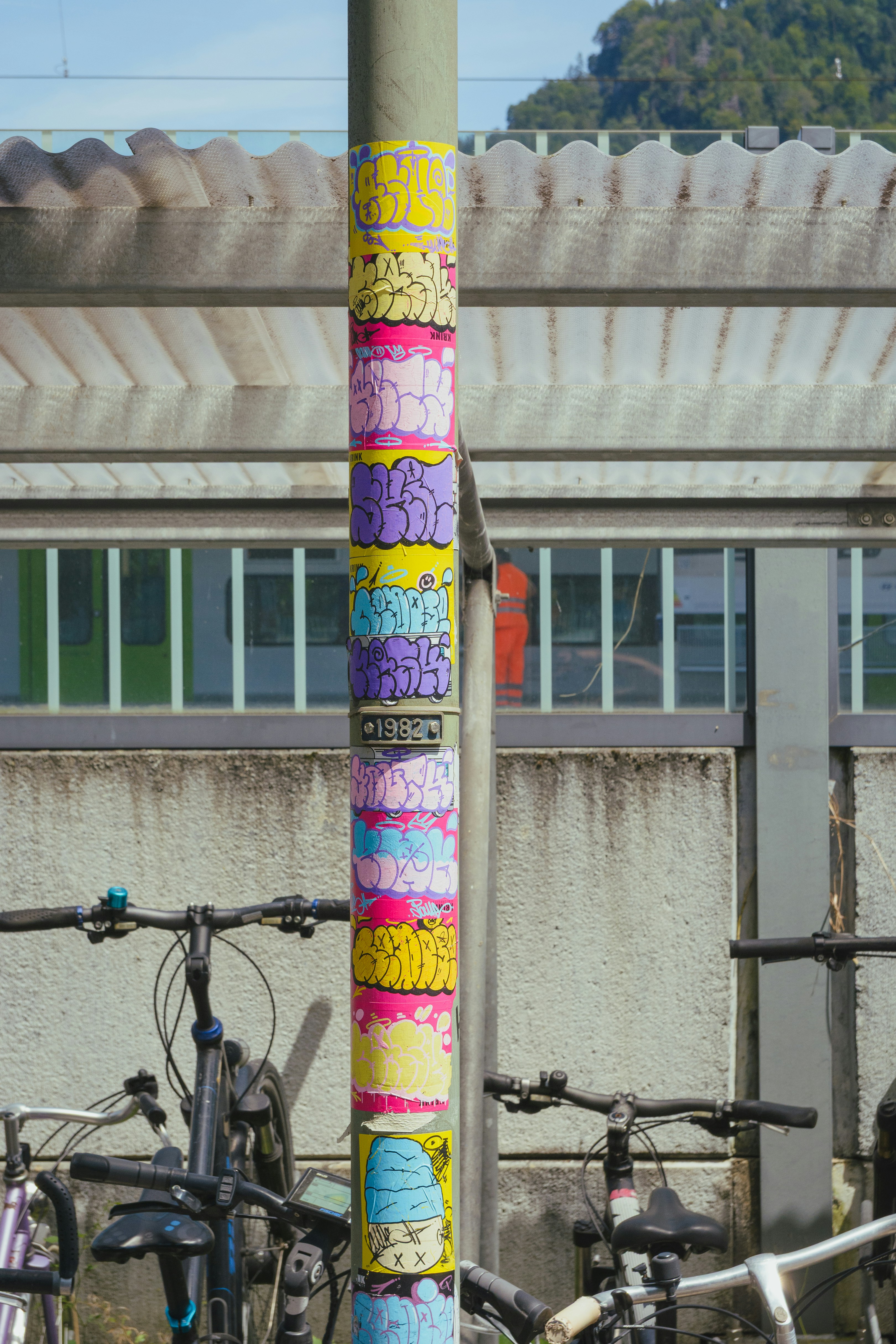Colorful Stickered Pole Anchoring a Quiet Bicycle Courtyard