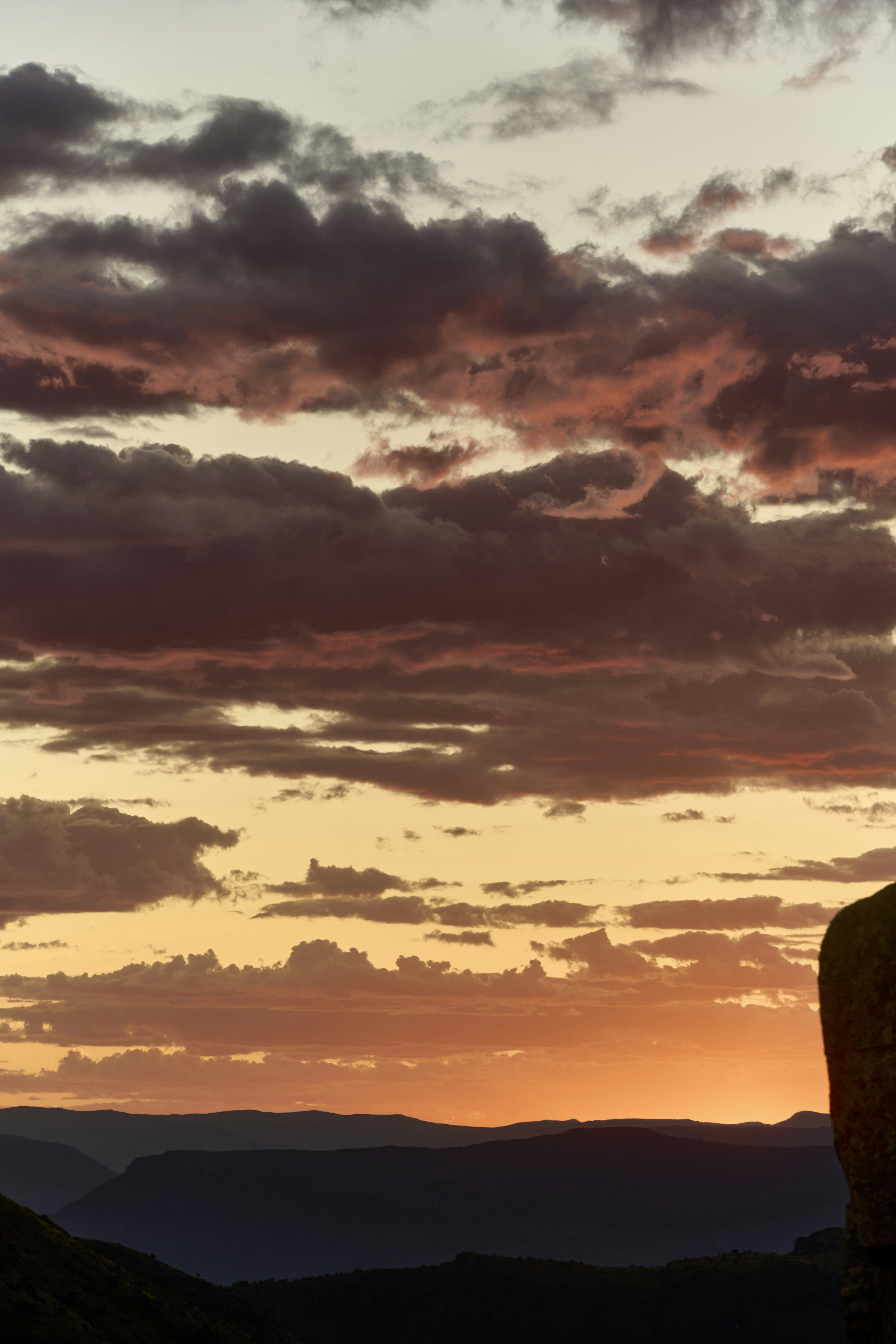 Sunset Over Rimrock: Silhouetted Cliffs and Layered Valleys
