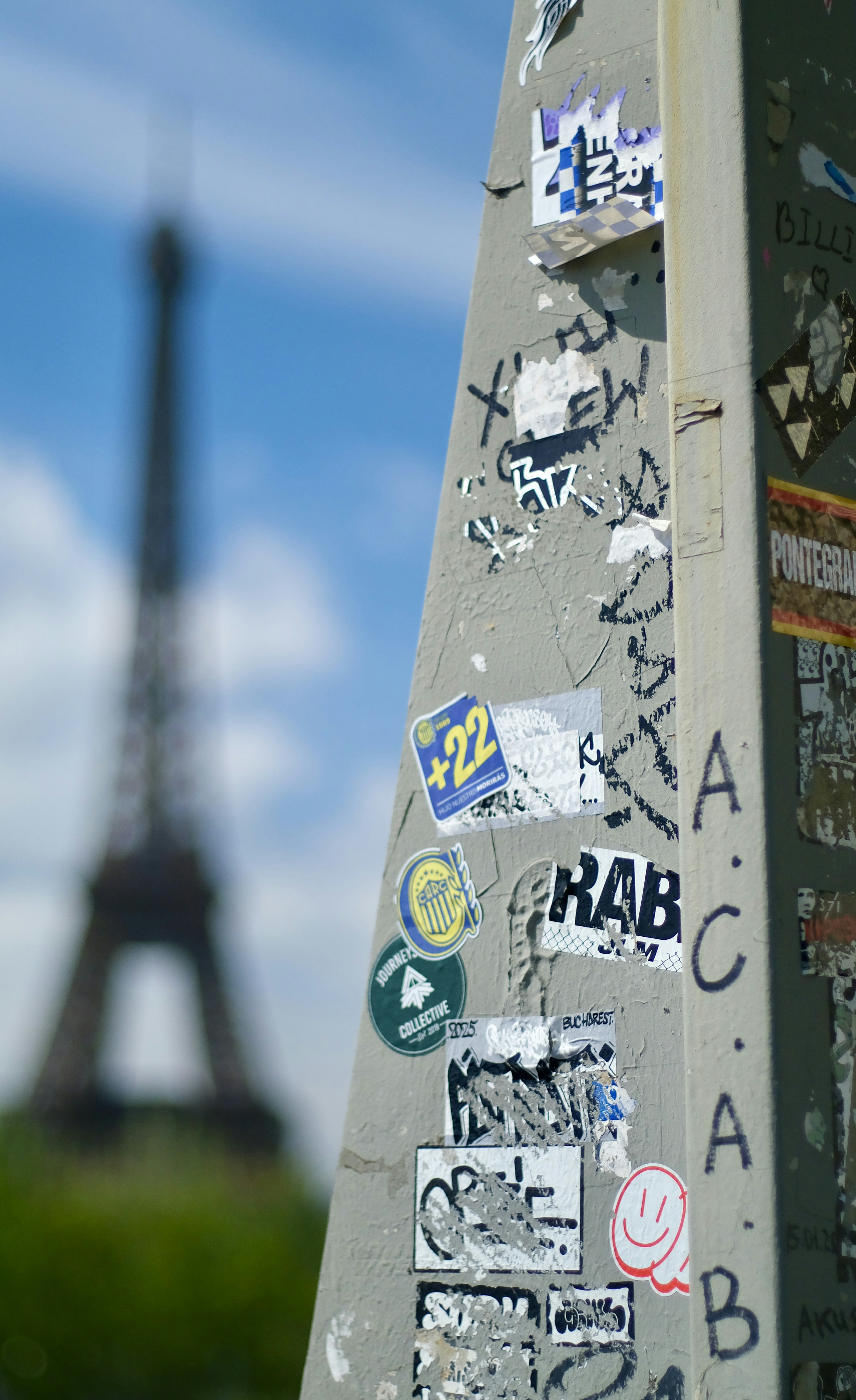 Eiffel tower in background, pillar covered in stickers photo – Free ...