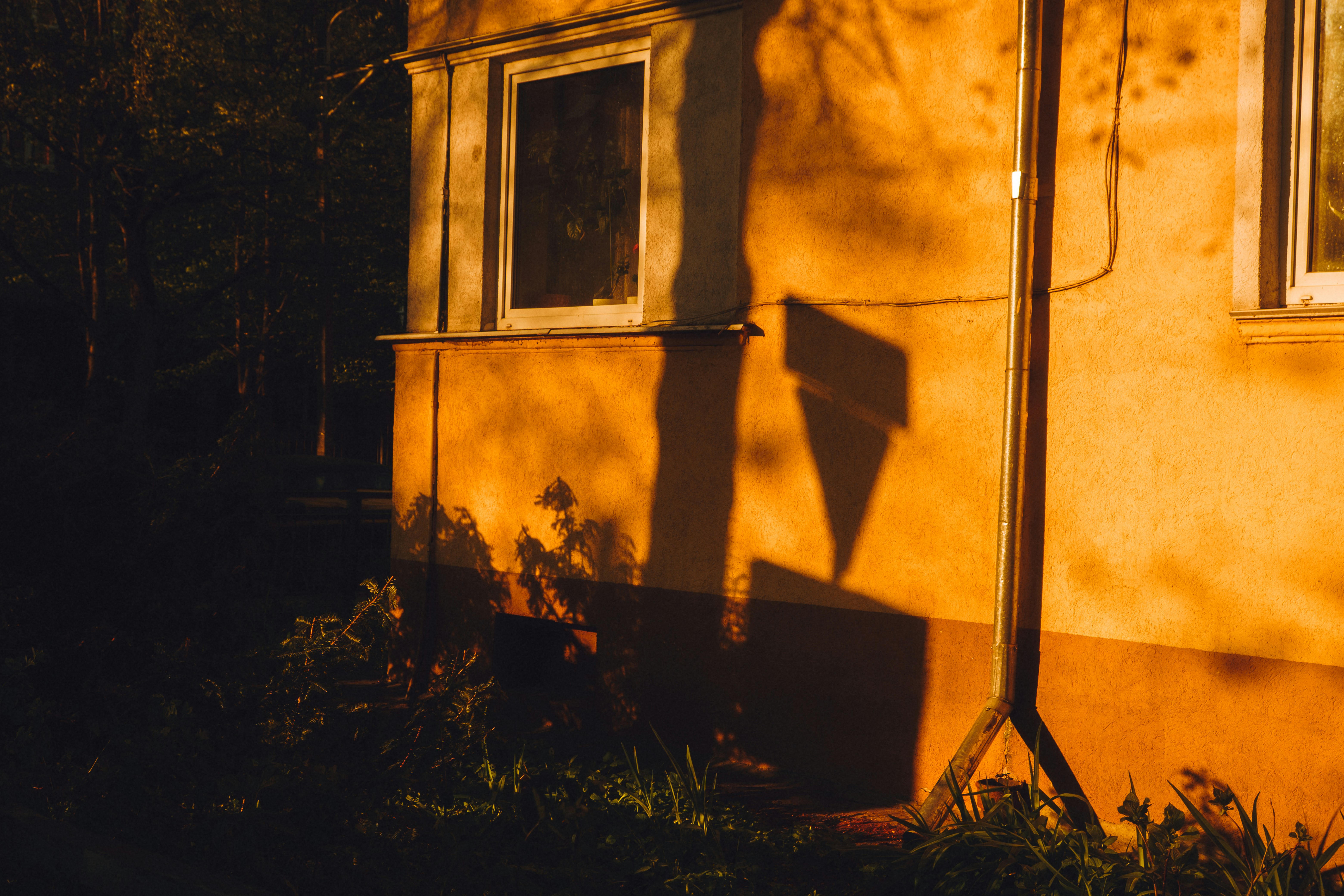 Sunlit Orange Facade and Shadowed Window