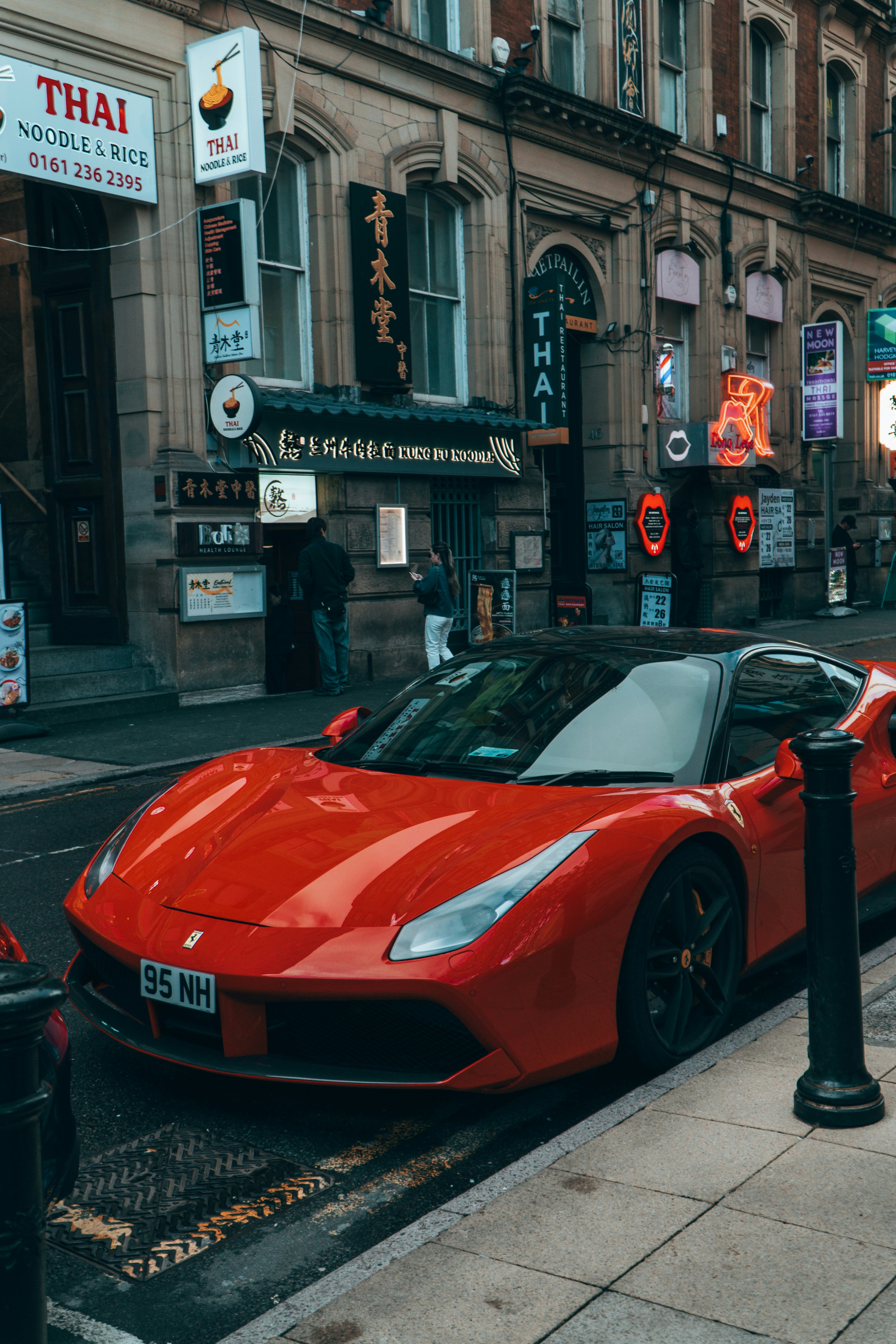 Crimson Ferrari at a Neon-Bathed City Street