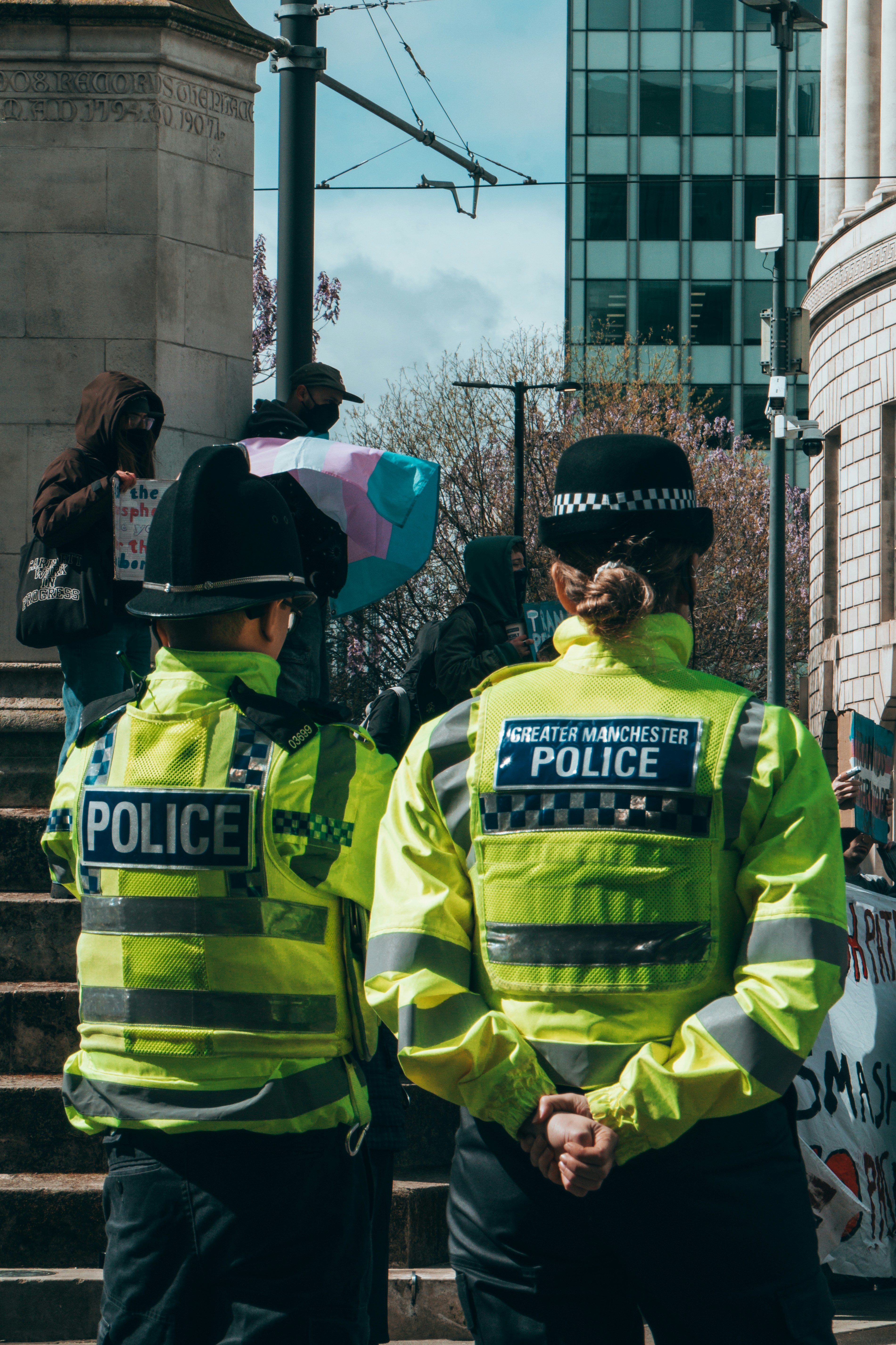 Two Police Officers in High-Visibility Jackets Guard a City Rally