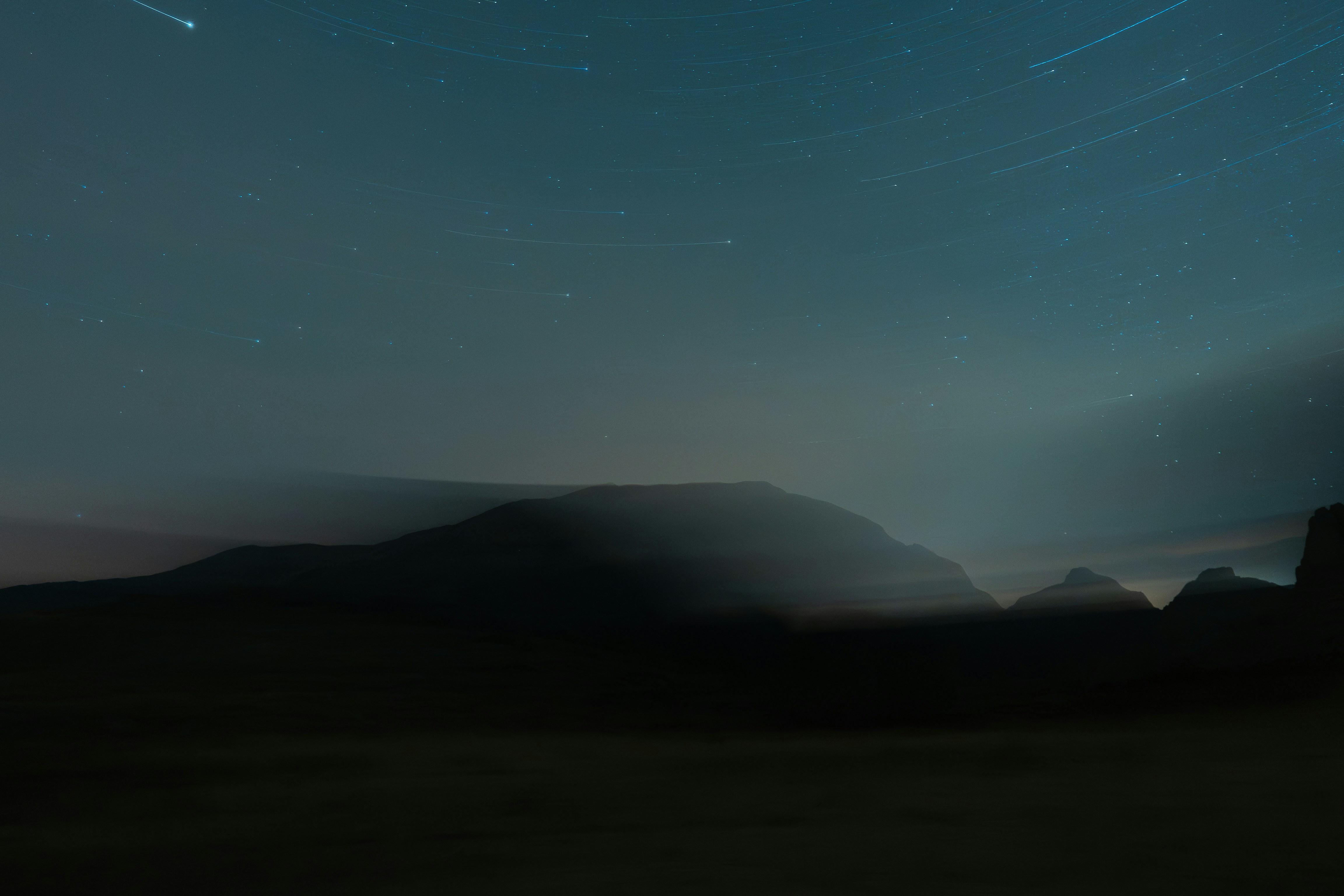 Silent Border: A Moonlit Ridge Under Star Trails