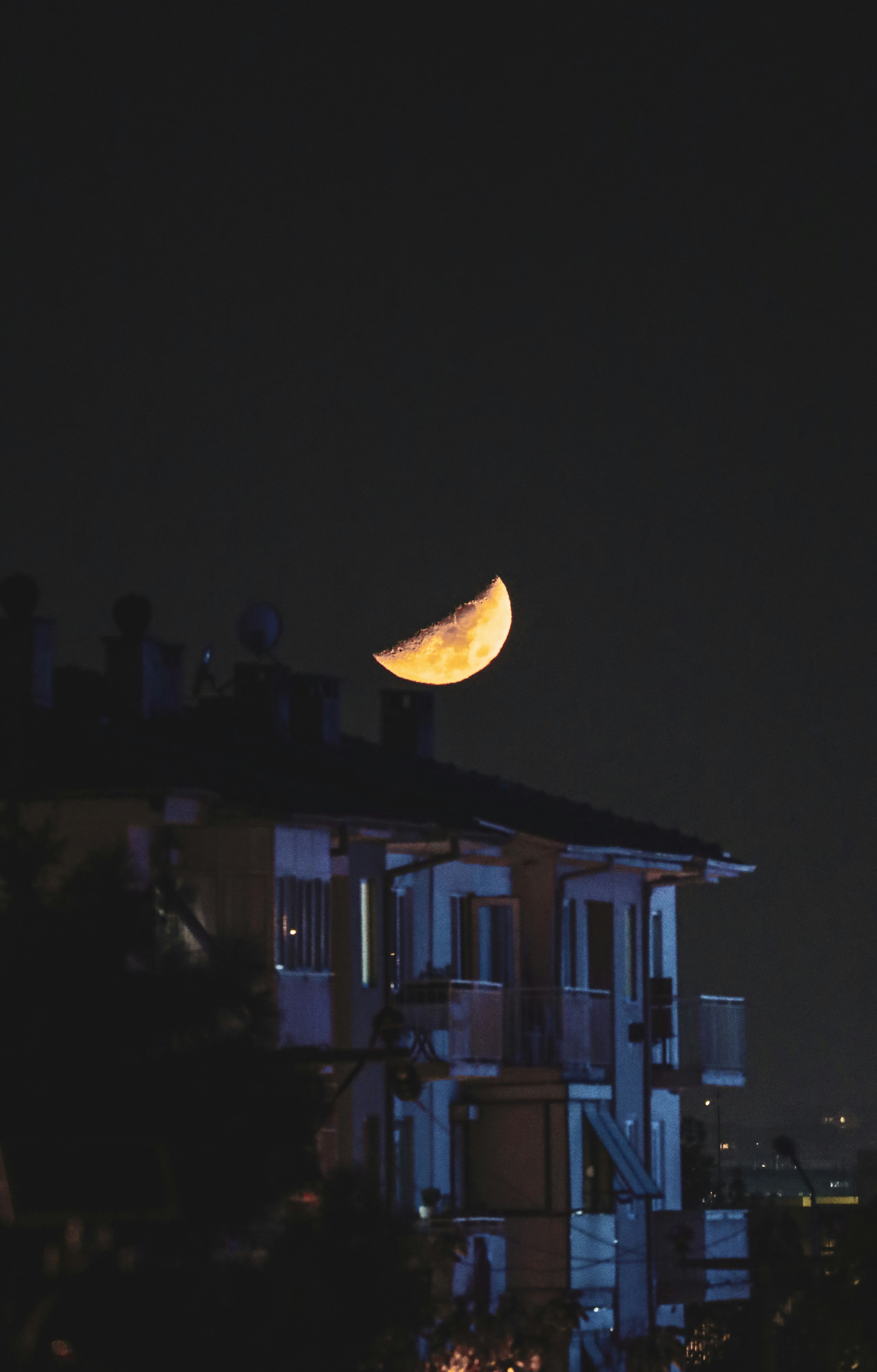 Orange Crescent: Moon Half-Laugh Above Quiet Rooftops