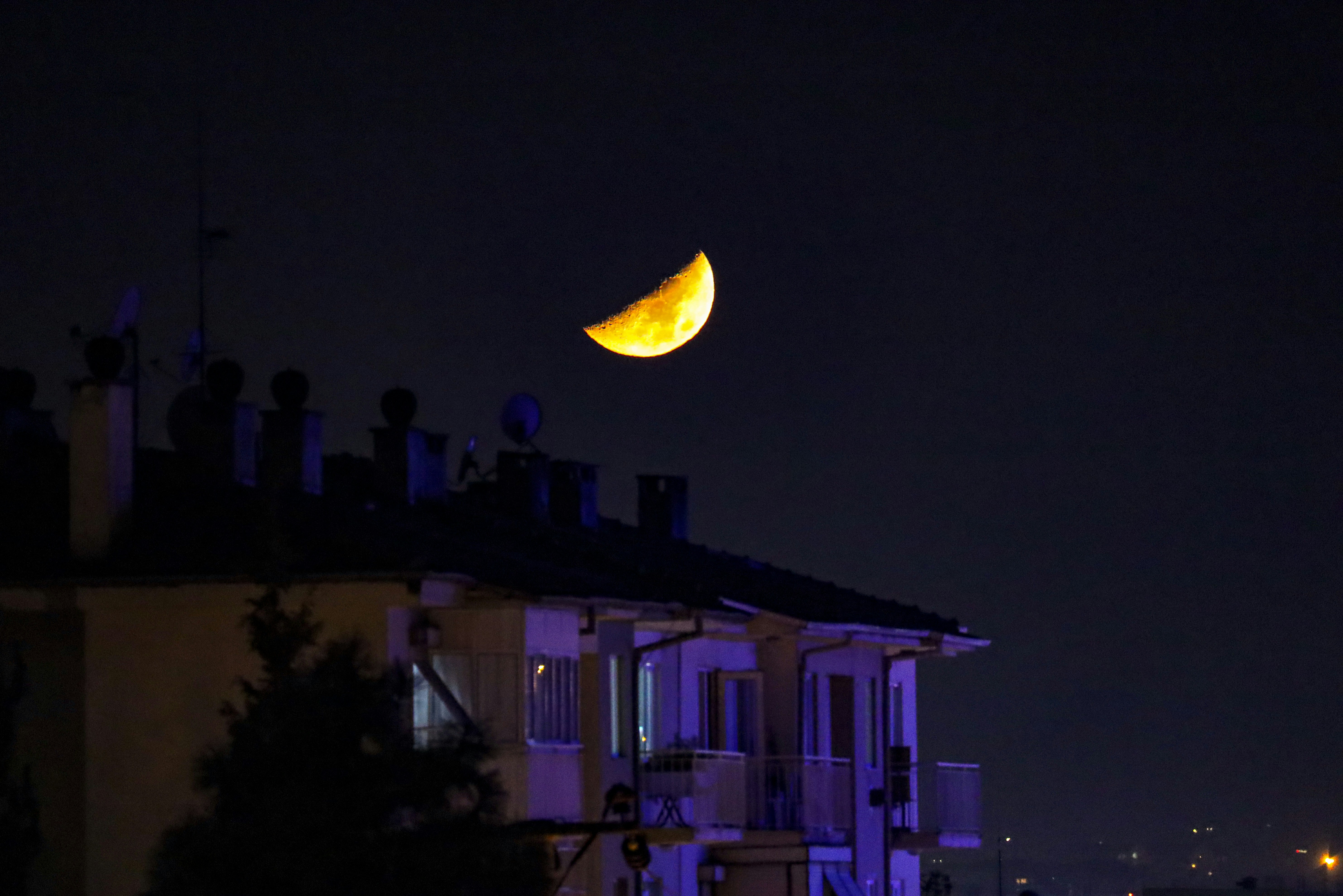 Lone Crescent Over a Quiet City Night