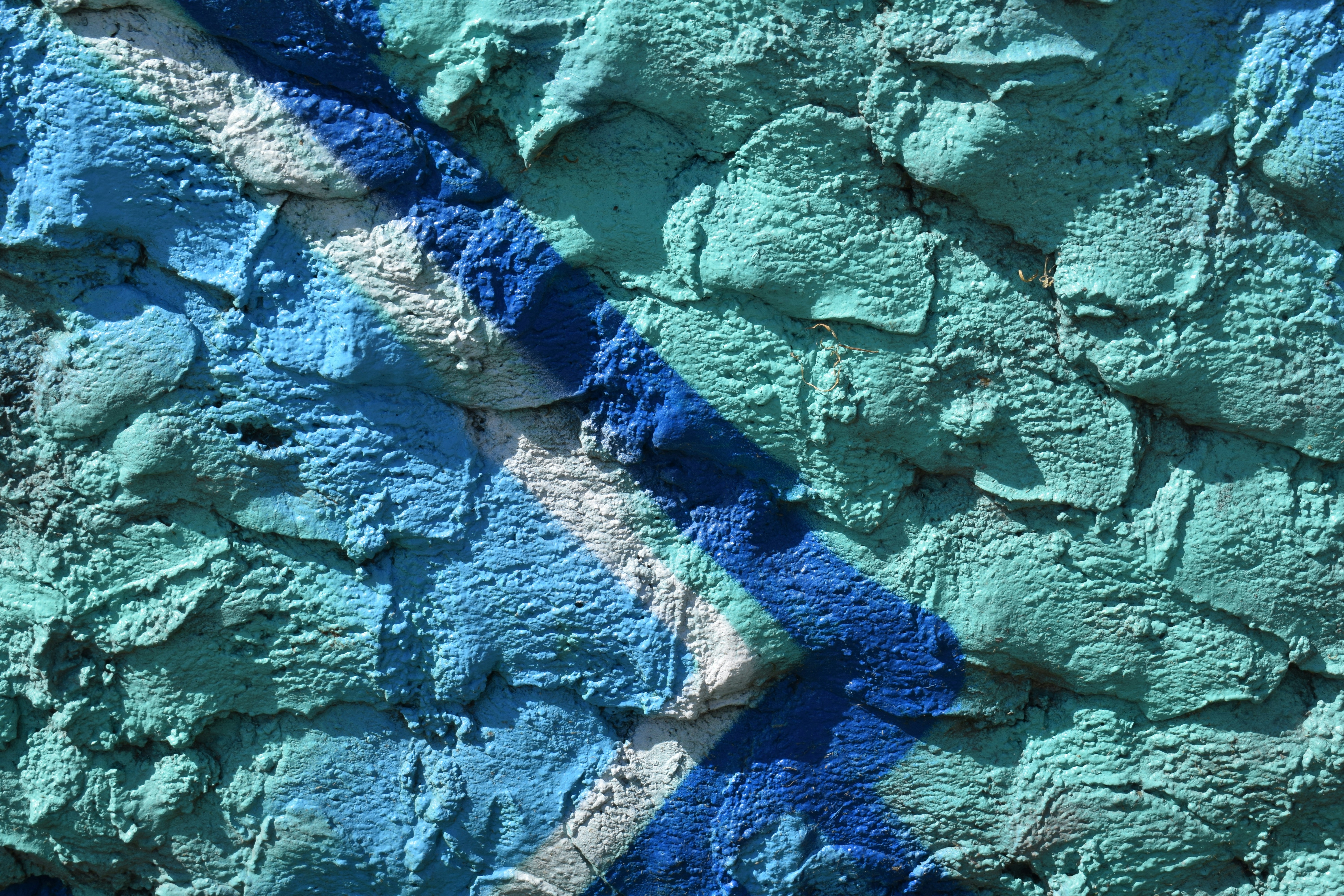 Diagonal Blue Stride Across a Coral-Cement Facade