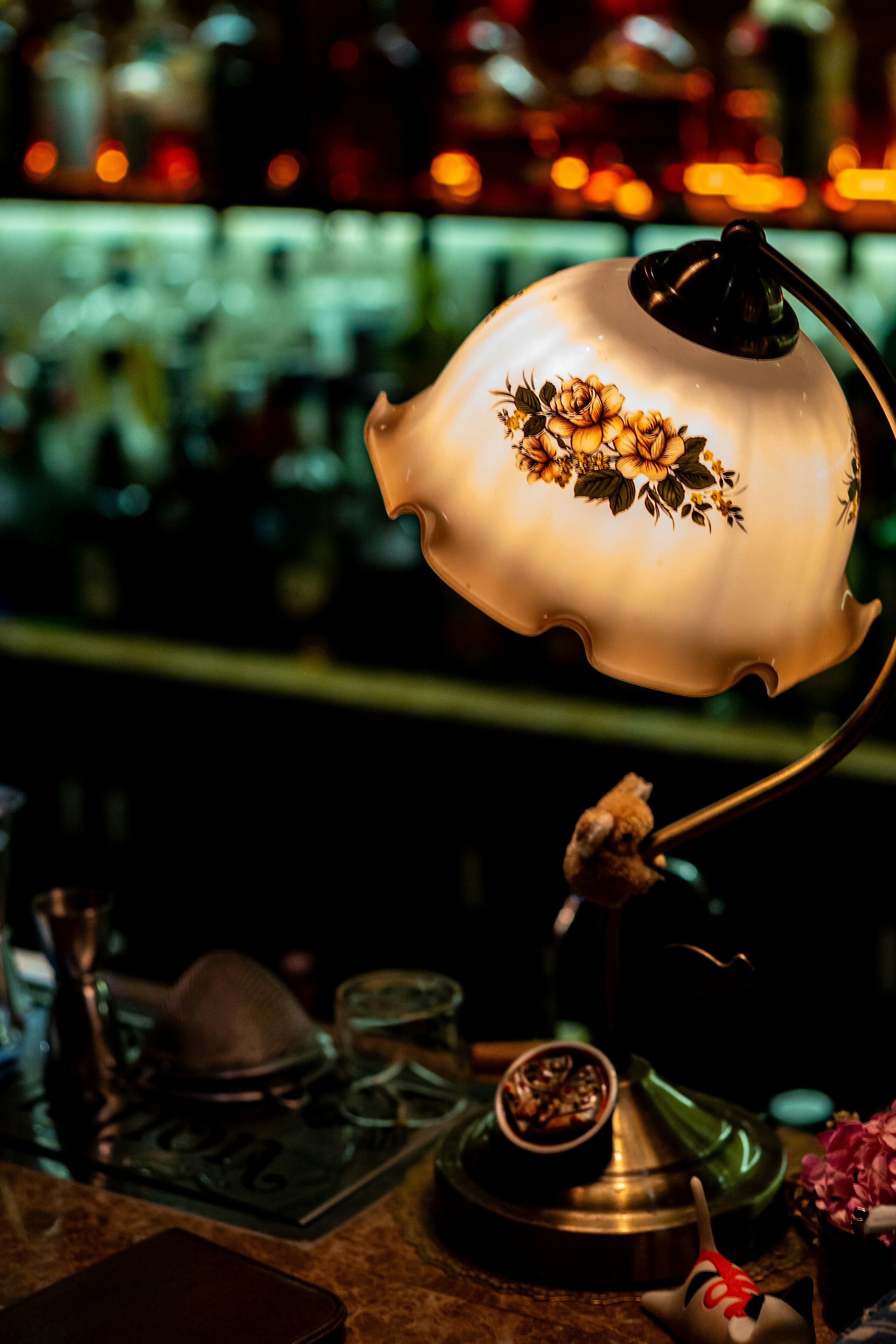 Luminous Shade: A Floral Lamp Illuminates a Quiet Bar