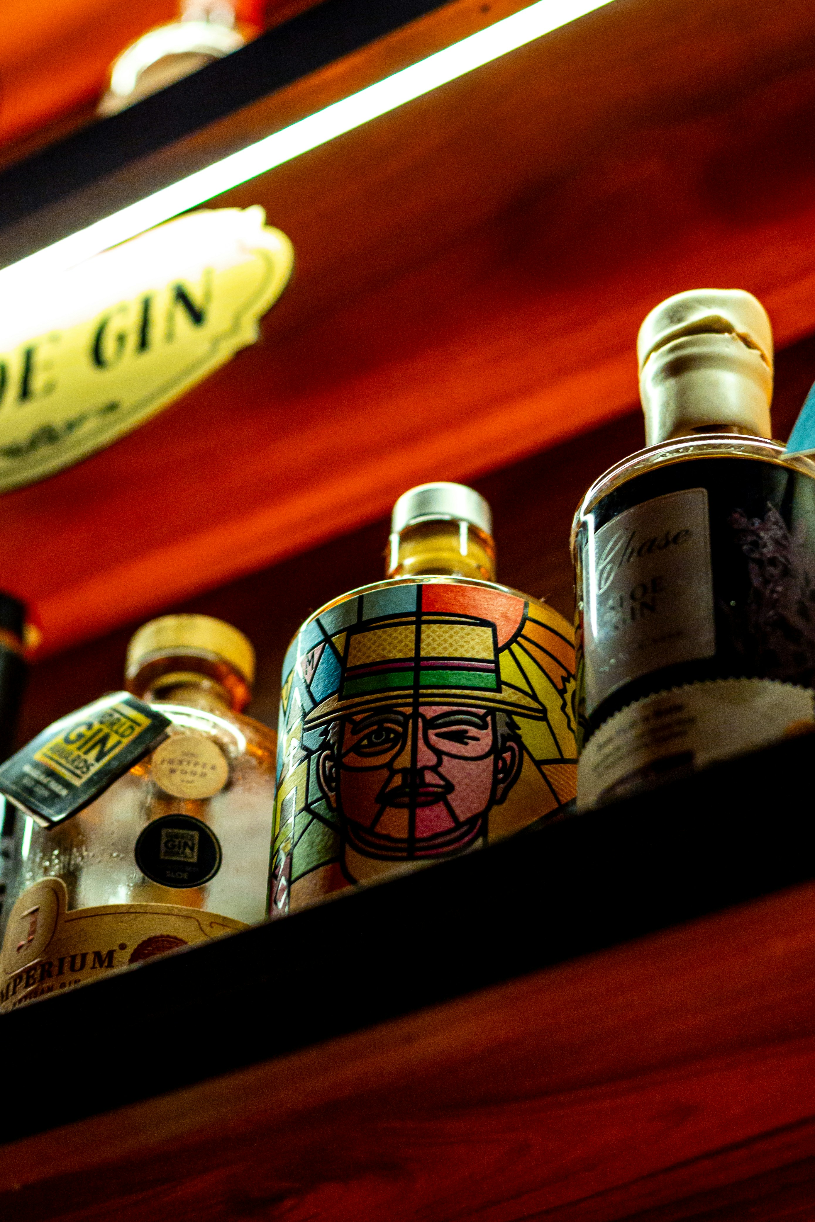 Colored Bottles with Pop-Art Labelry on a Backlit Shelf