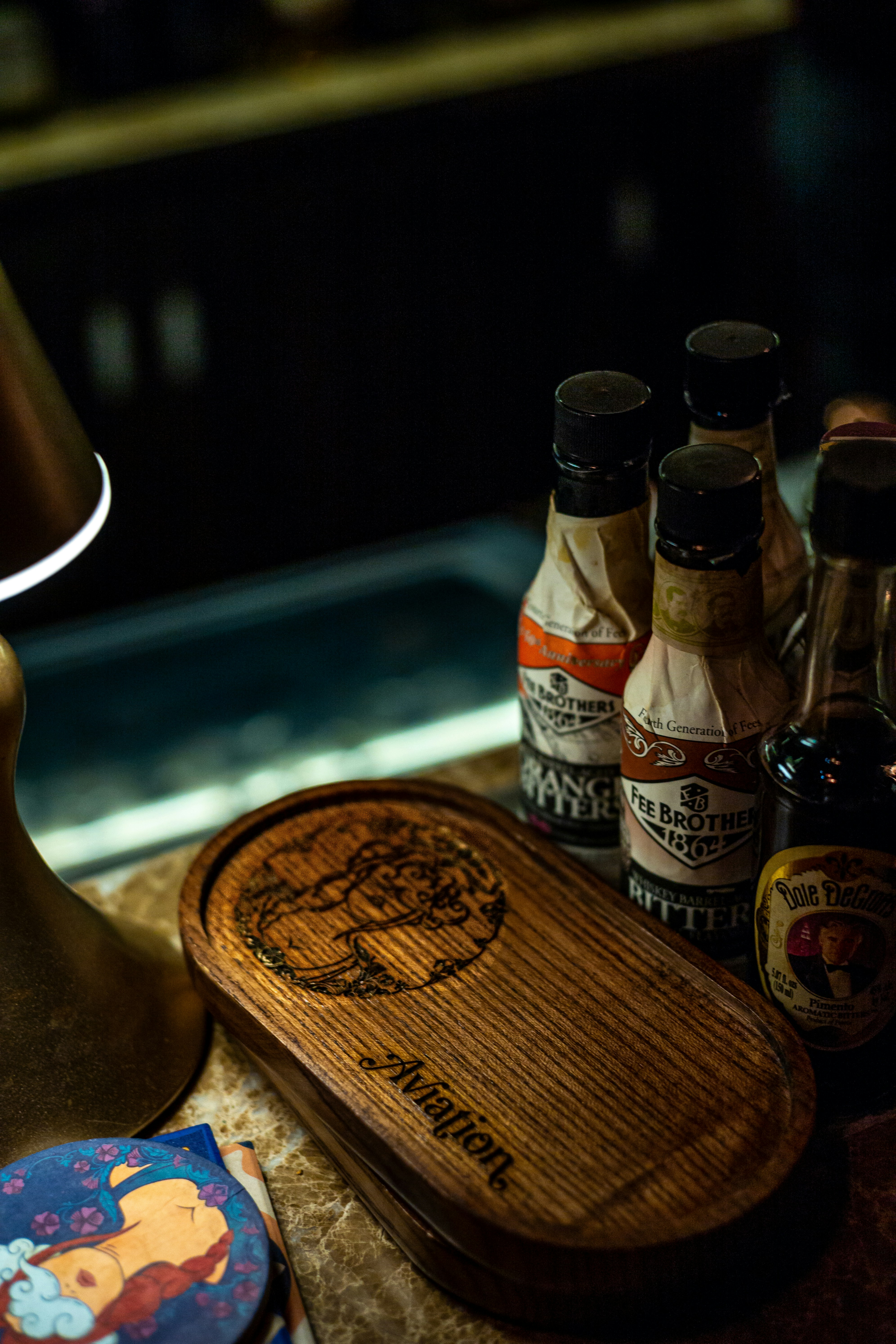 Wooden humidor and bottled bitters at a bar counter