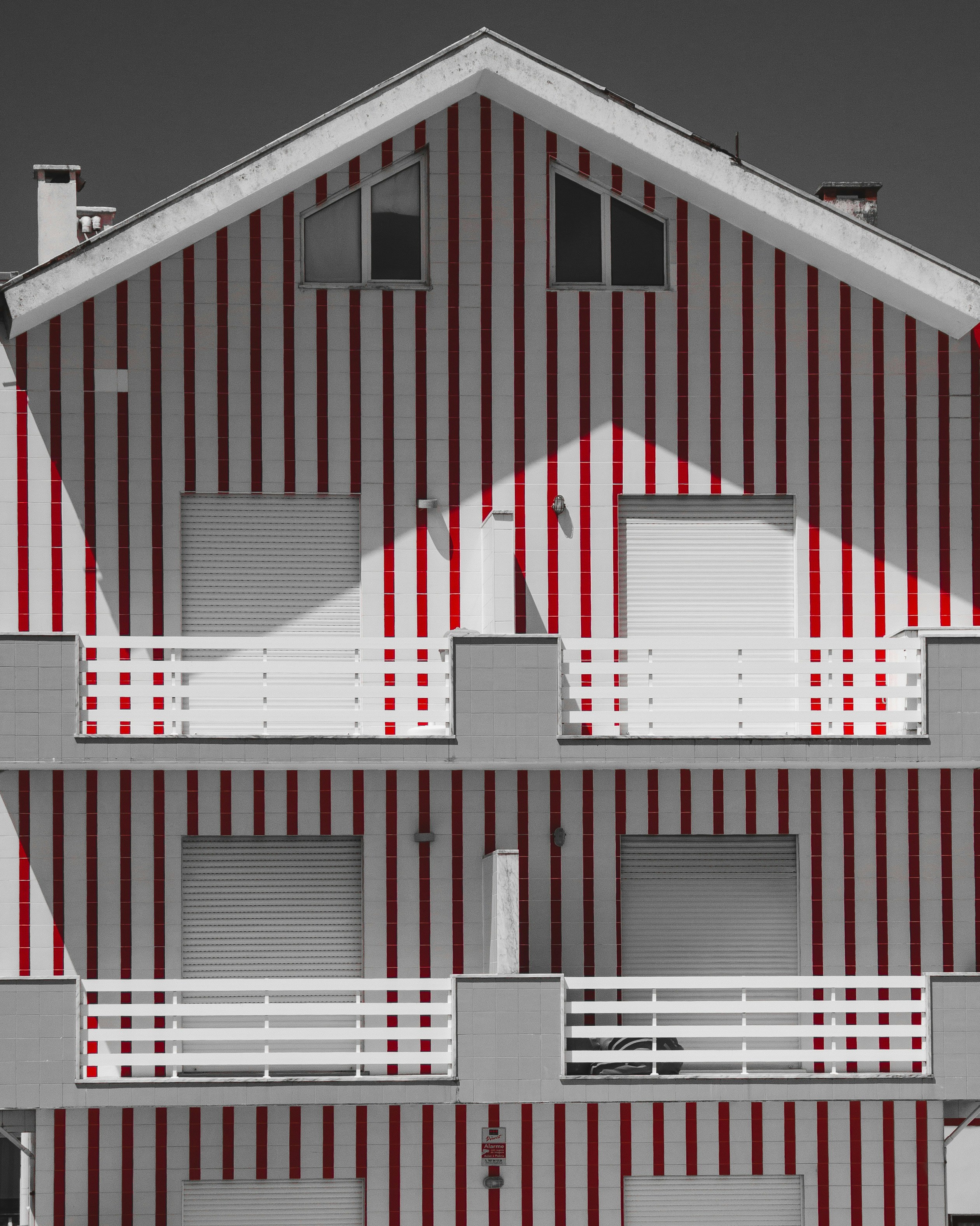 Red-and-white striped facade: a geometric residence with stacked balconies