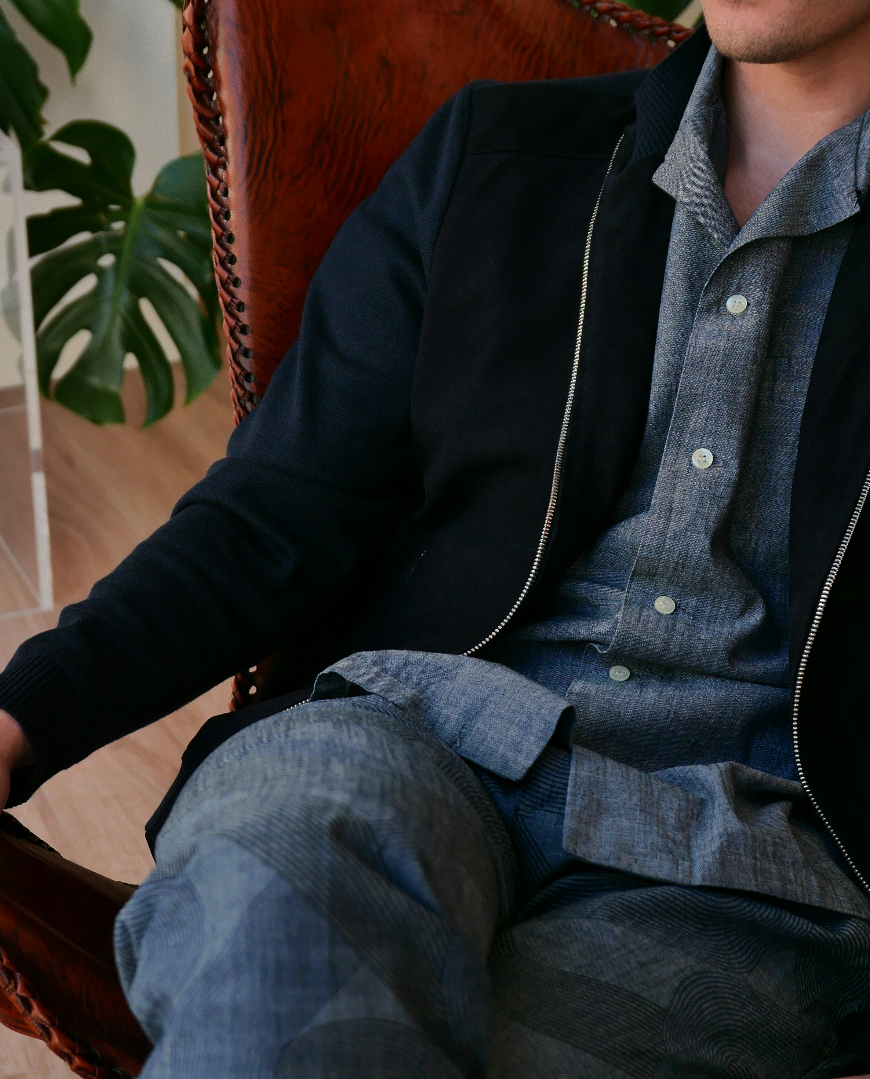 Relaxed Confidence: A Man in a Navy Jacket Reclines in a Leather Chair