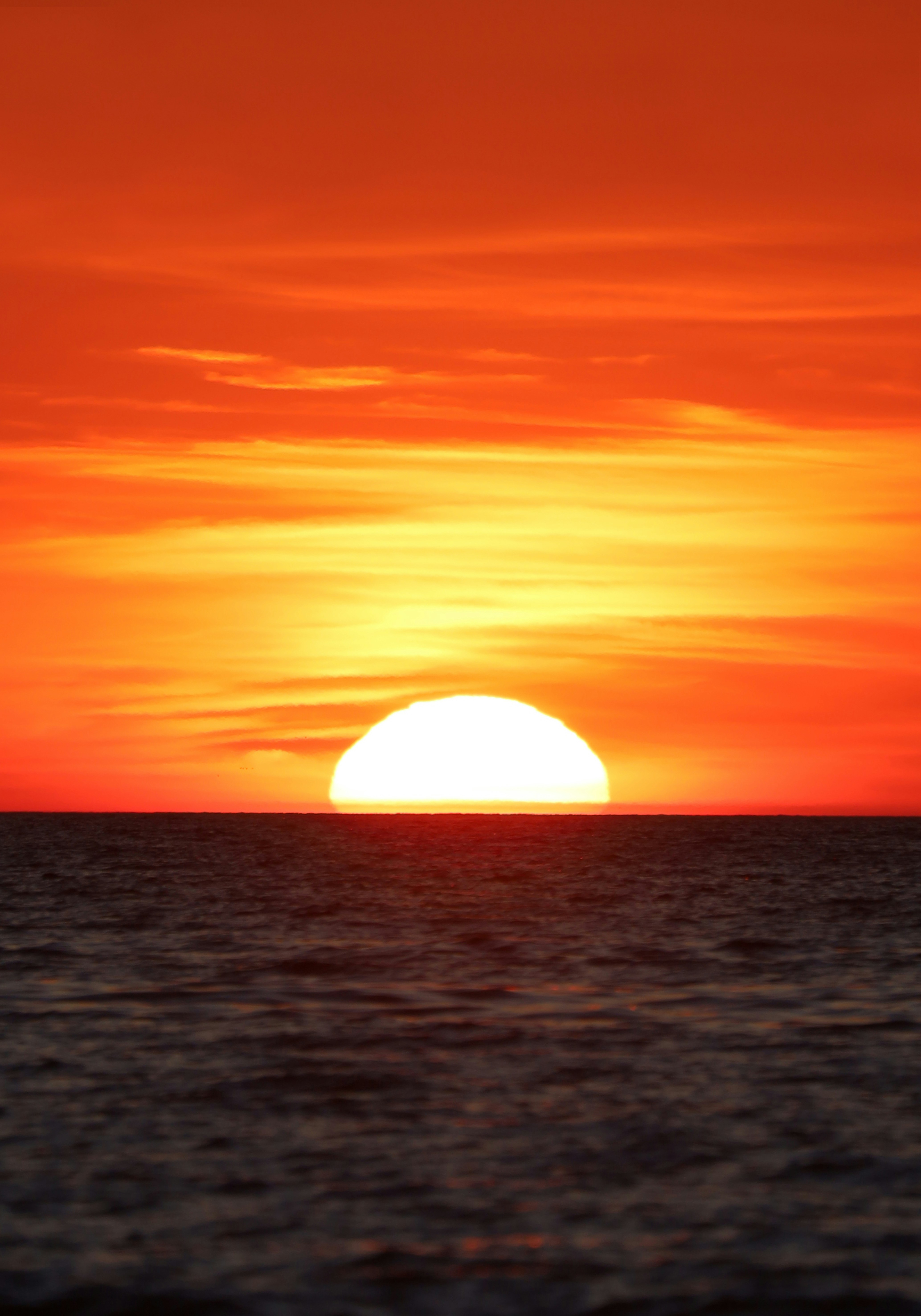 Bold Horizon: The Sun Dips Over a Choppy Sea