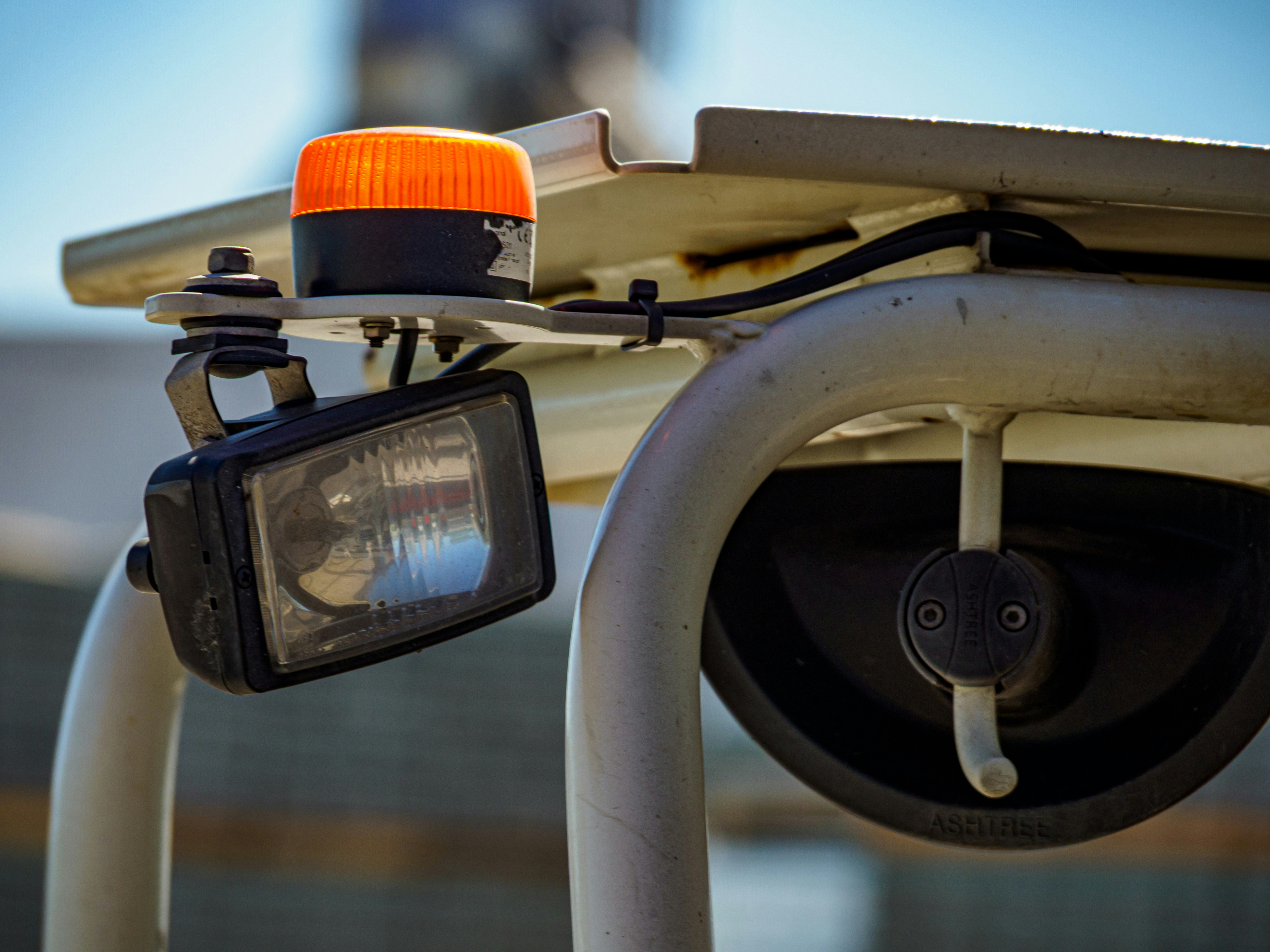 Industrial Spotlight: A close-up of a small wheeled device’s lens and orange beacon