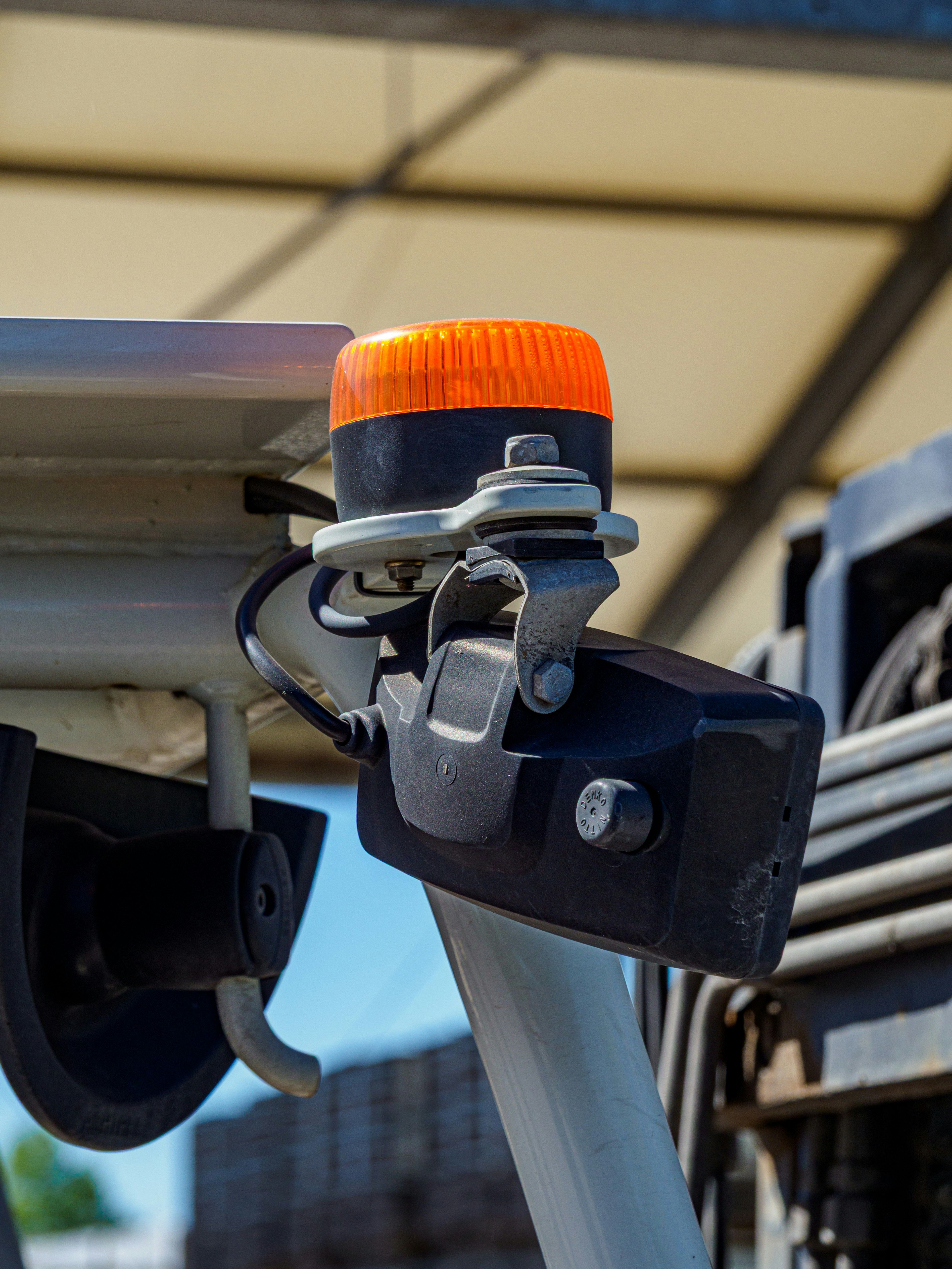 Industrial camera beacon: orange lamp atop a rugged mount