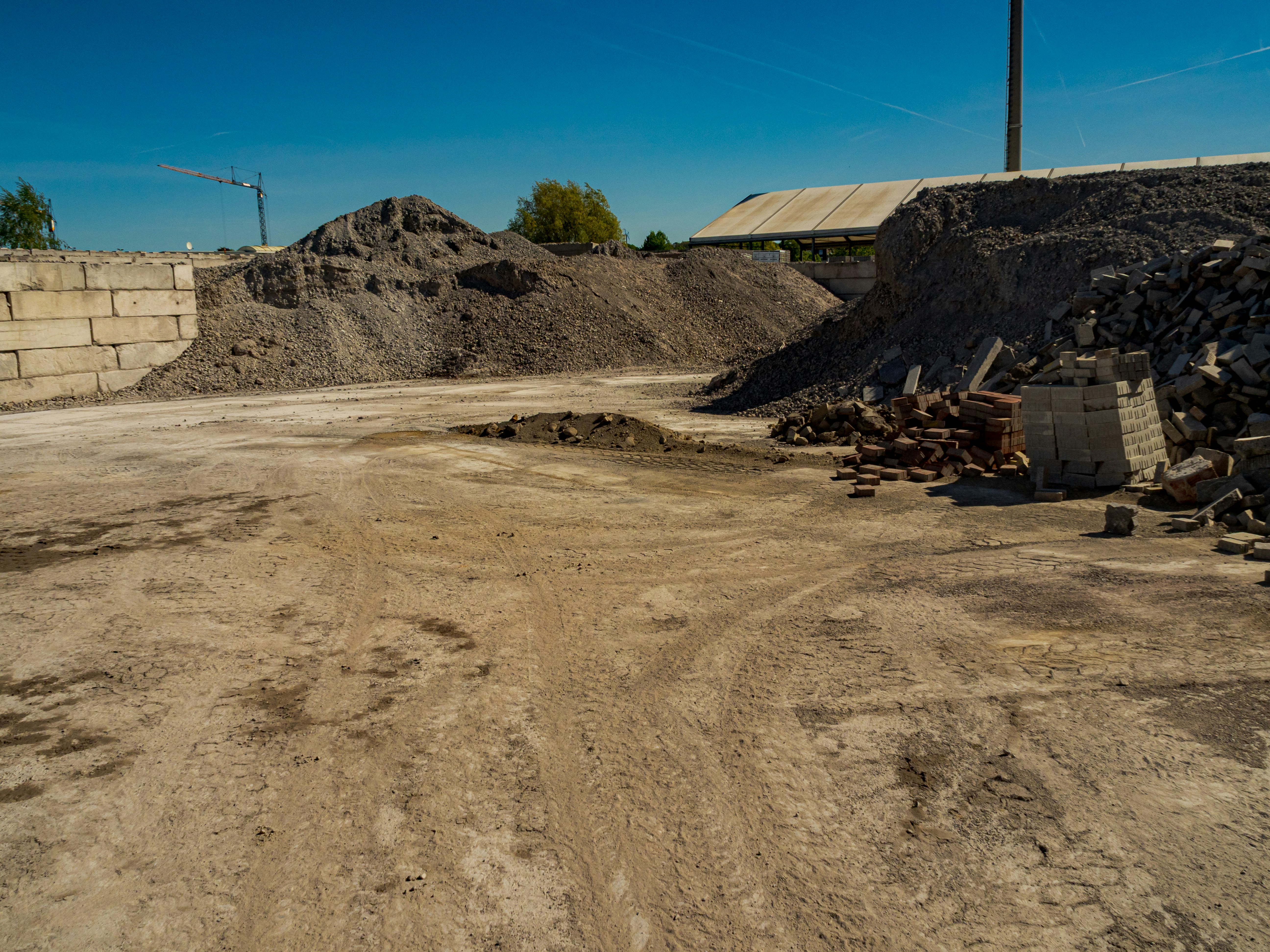 Dusty Yardfront: A Quiet Excavation Scene with Piles and Bricks