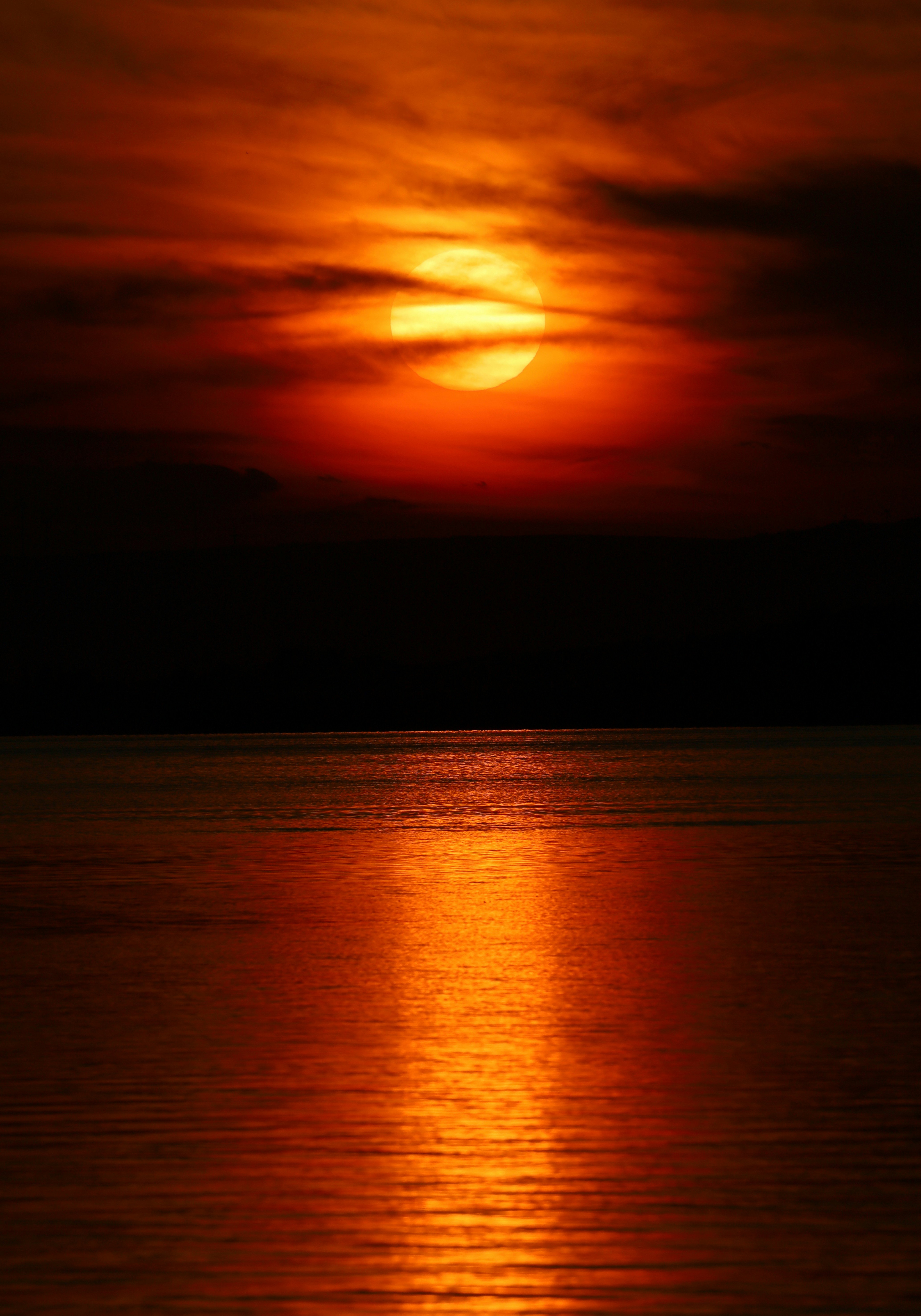 Sunset on the Water: A Golden Silhouette over Quiet Waves