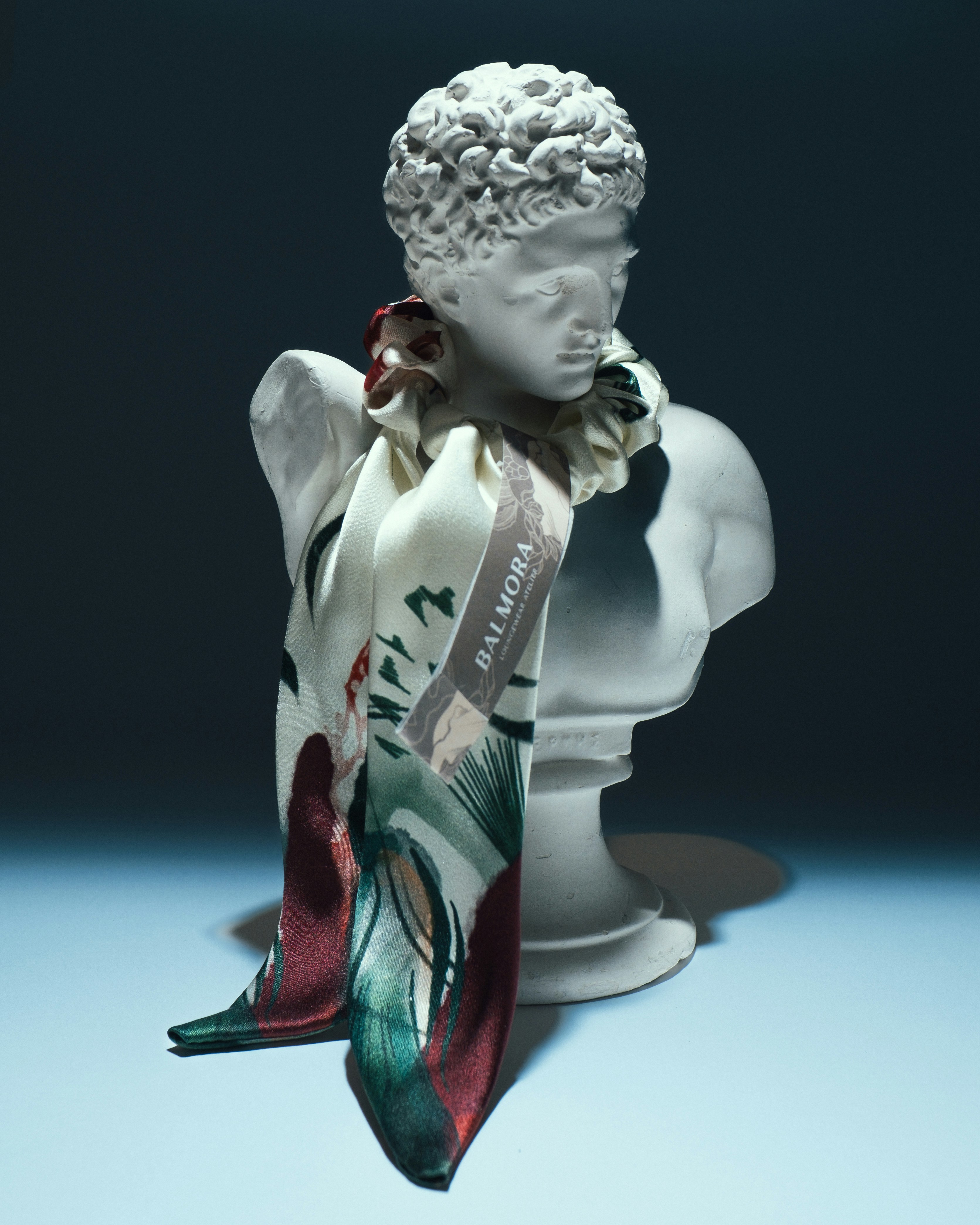 Scarves and Shadows: A Marble Bust Under Spotlight