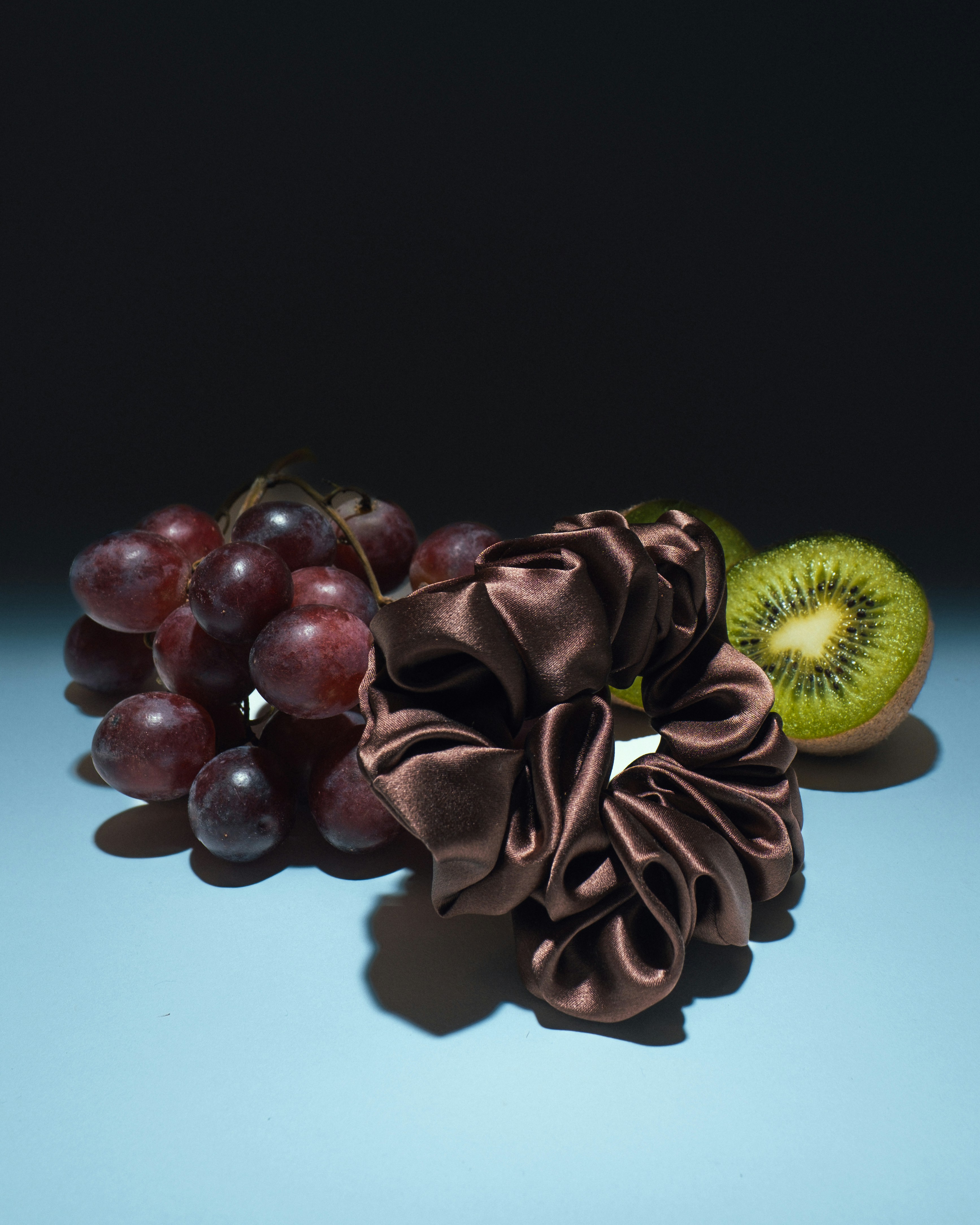 Chocolate Scrunch: a Chocolate Scrunchie Resting Among Kiwi and Grapes