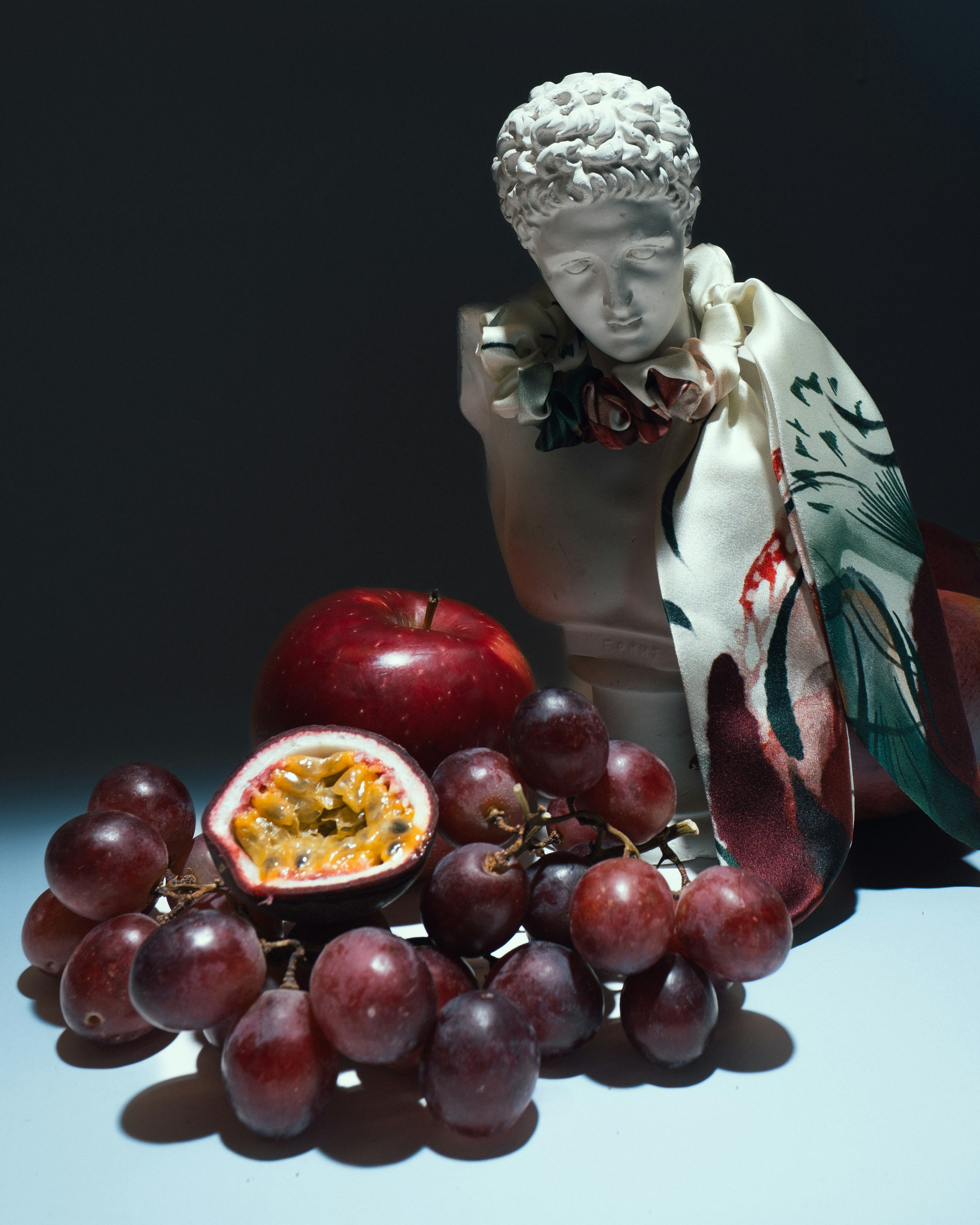 Sculpted Stillness: A Classical Bust Amid Fragrant Fruit
