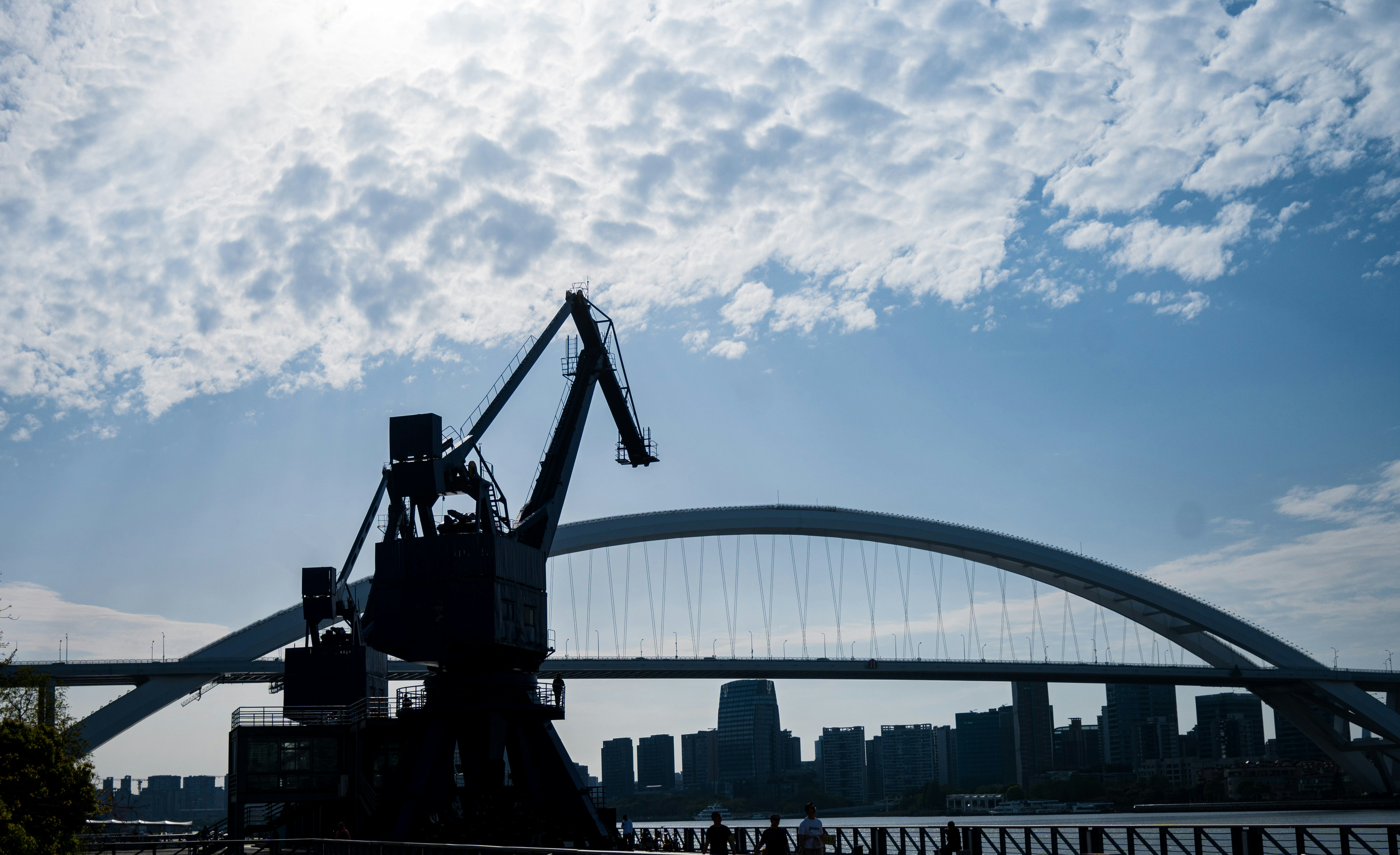 Crane Over the River: Silhouette of Industry Against a Bright Sky