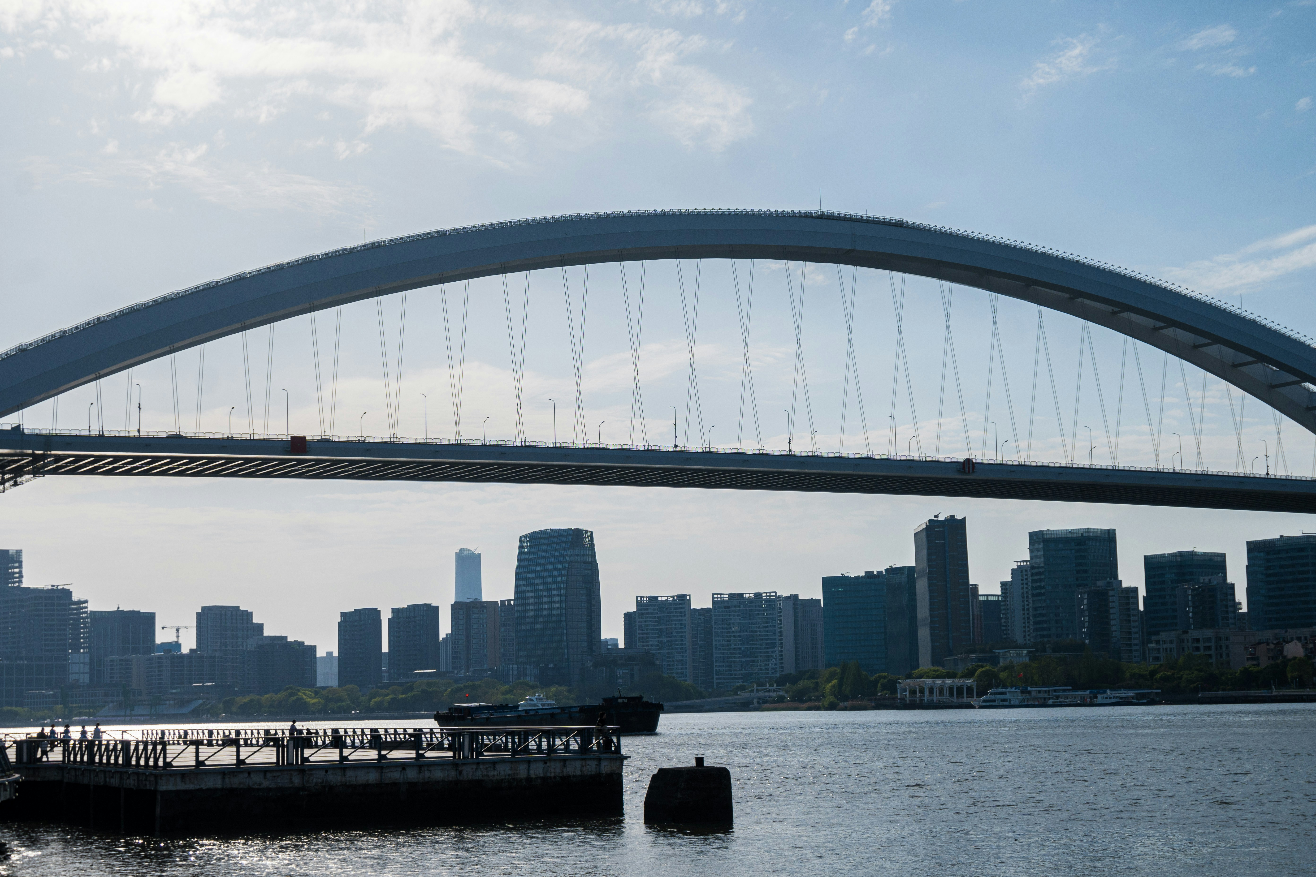 Bridge Ribbon over the River: Urban Skyline under a Sweeping Arch