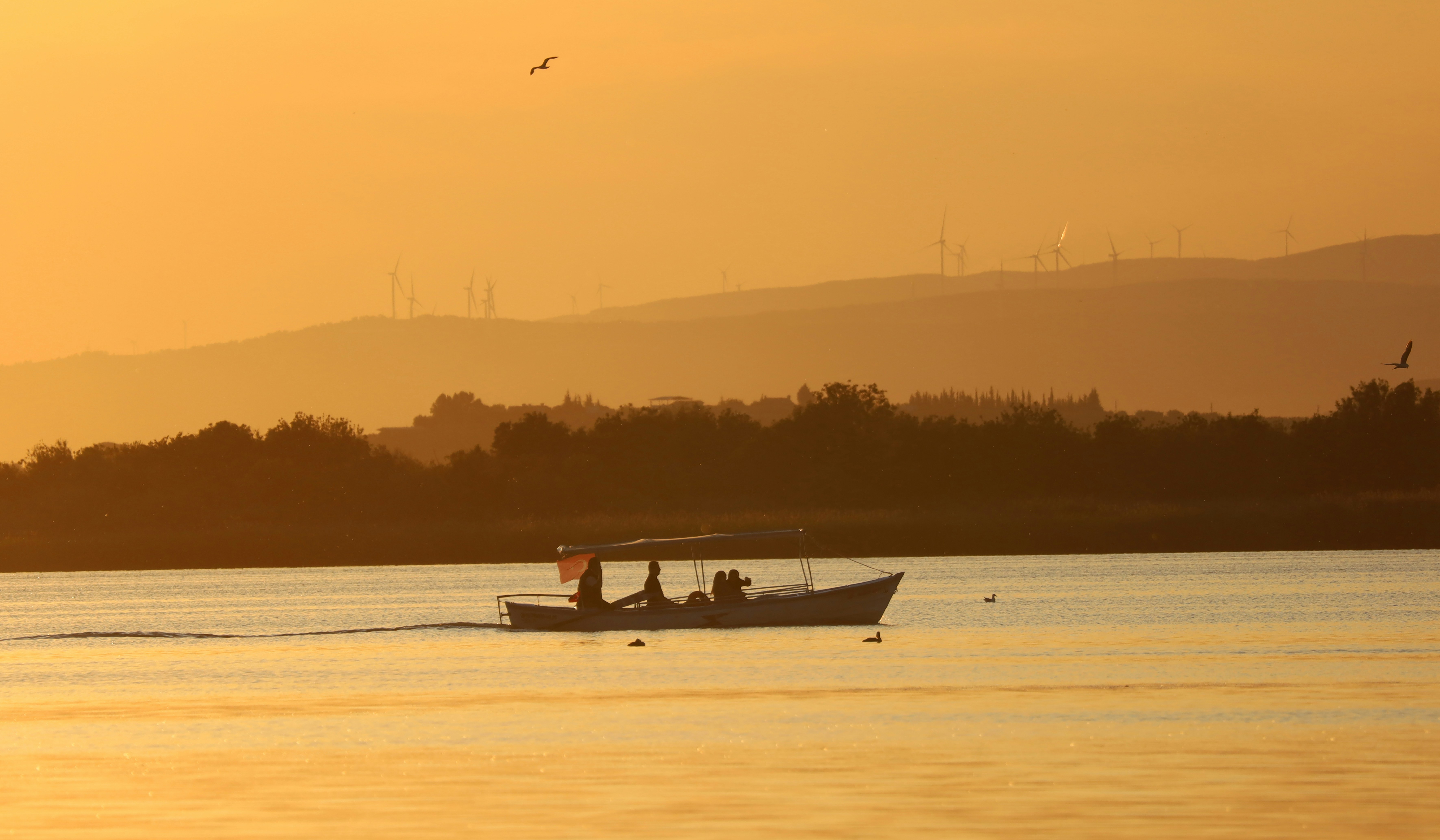 Golden Hour Commute: Silhouette Boat on Quiet Water
