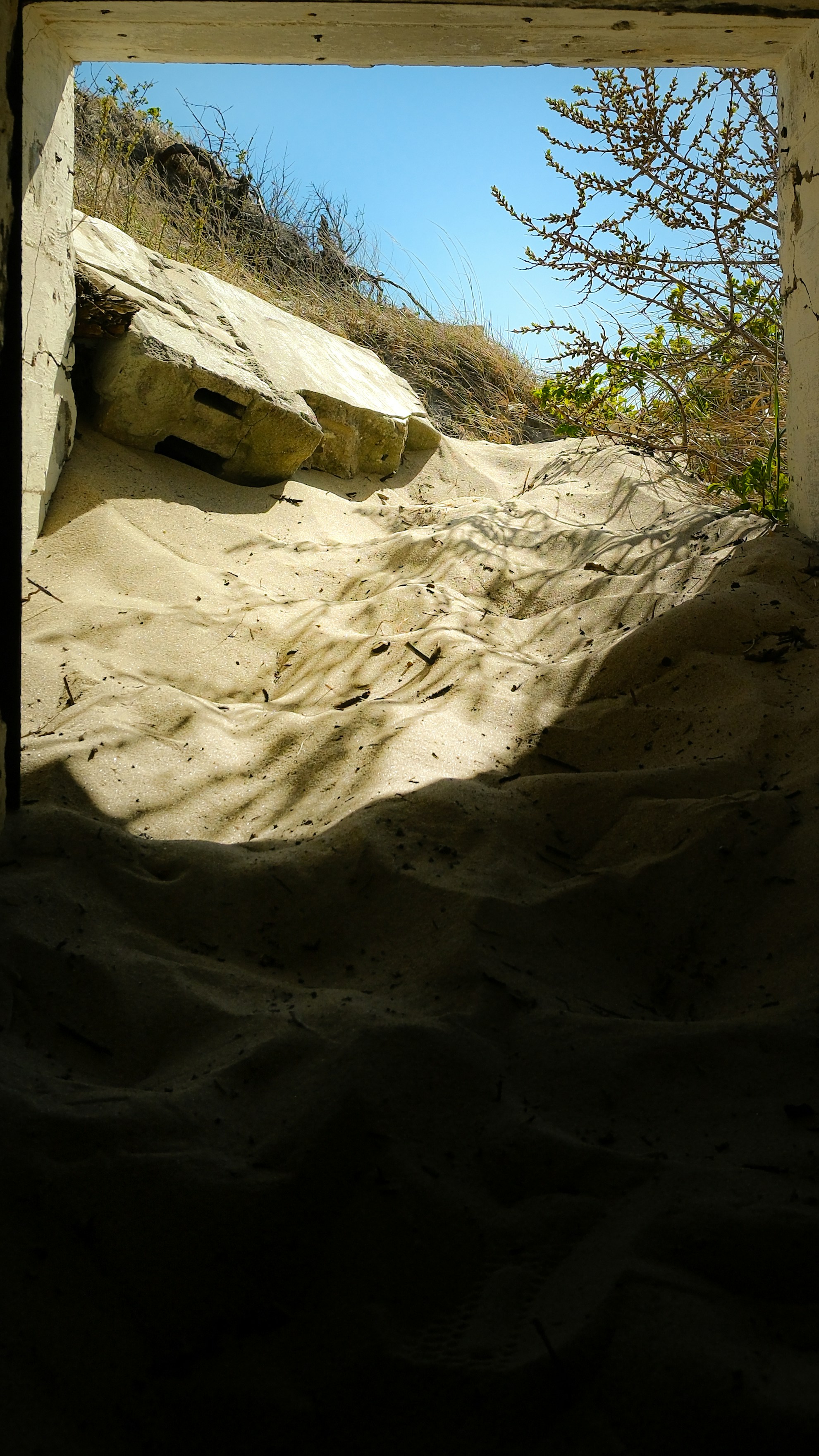 Sunlit Sand and Concrete Frame: A Hidden Coastal Passage