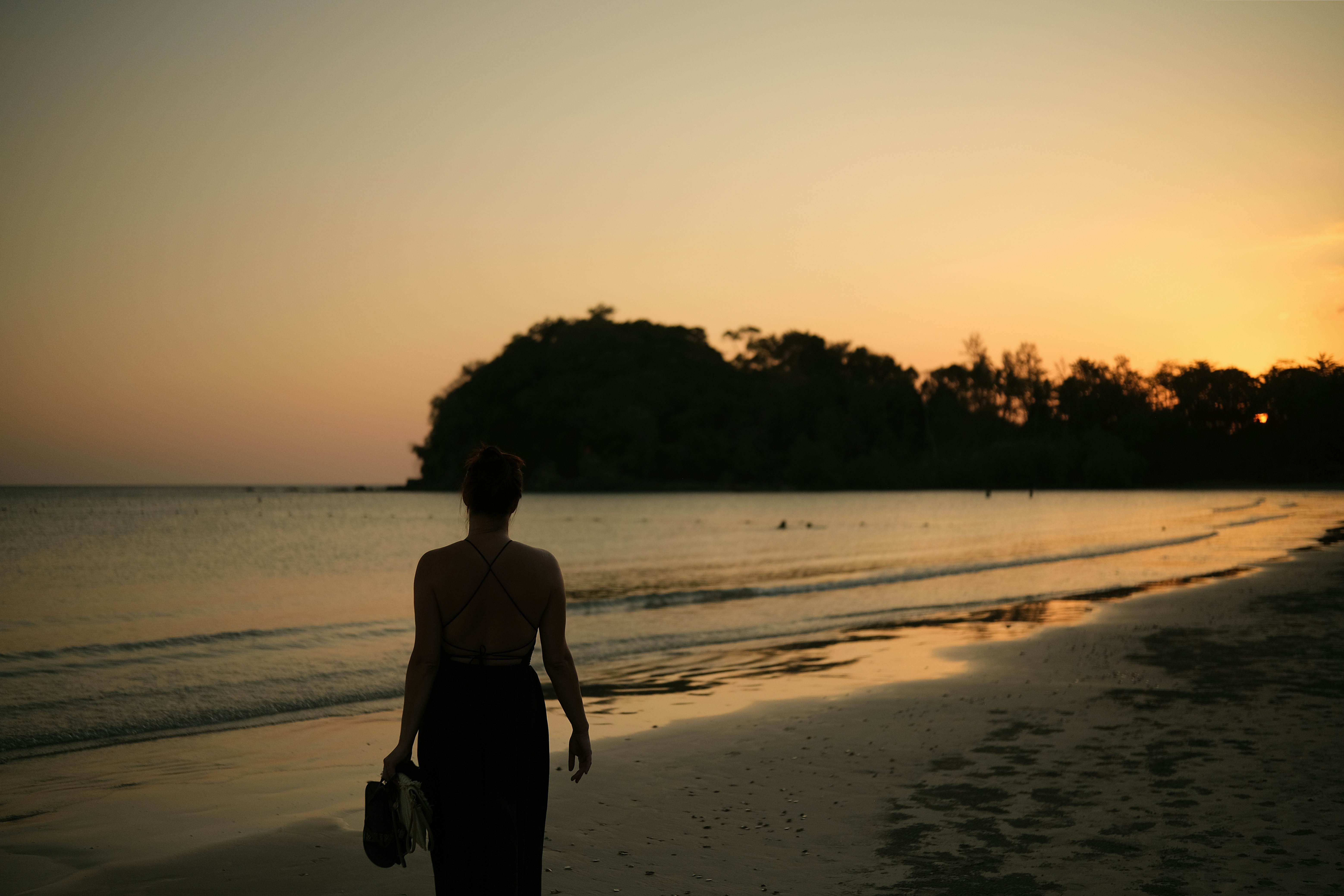 Silhouette Crossing the Quiet Shore at Sunset