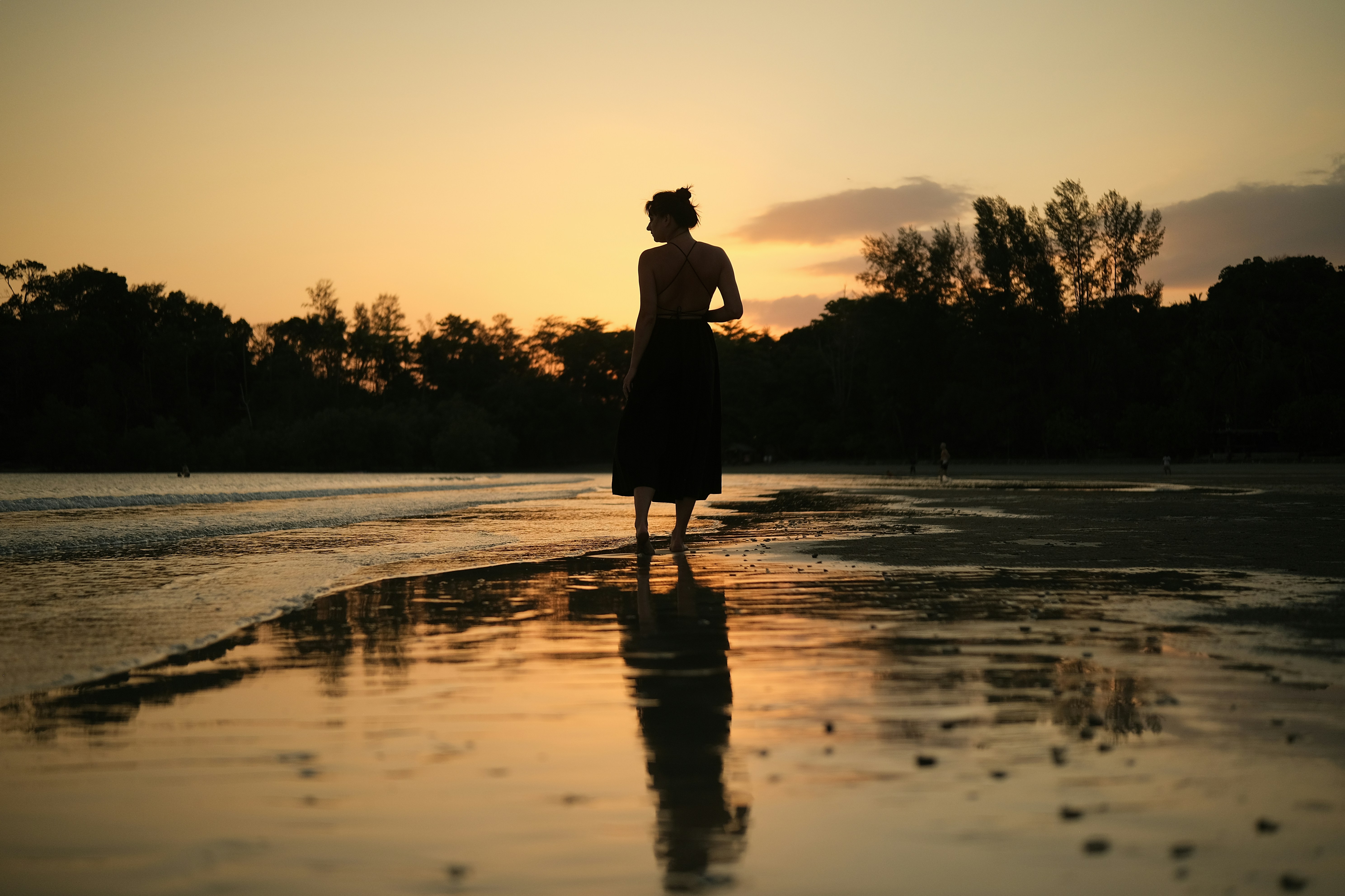 Silhouette at the Waterline: A Solitary Figure at Sunset