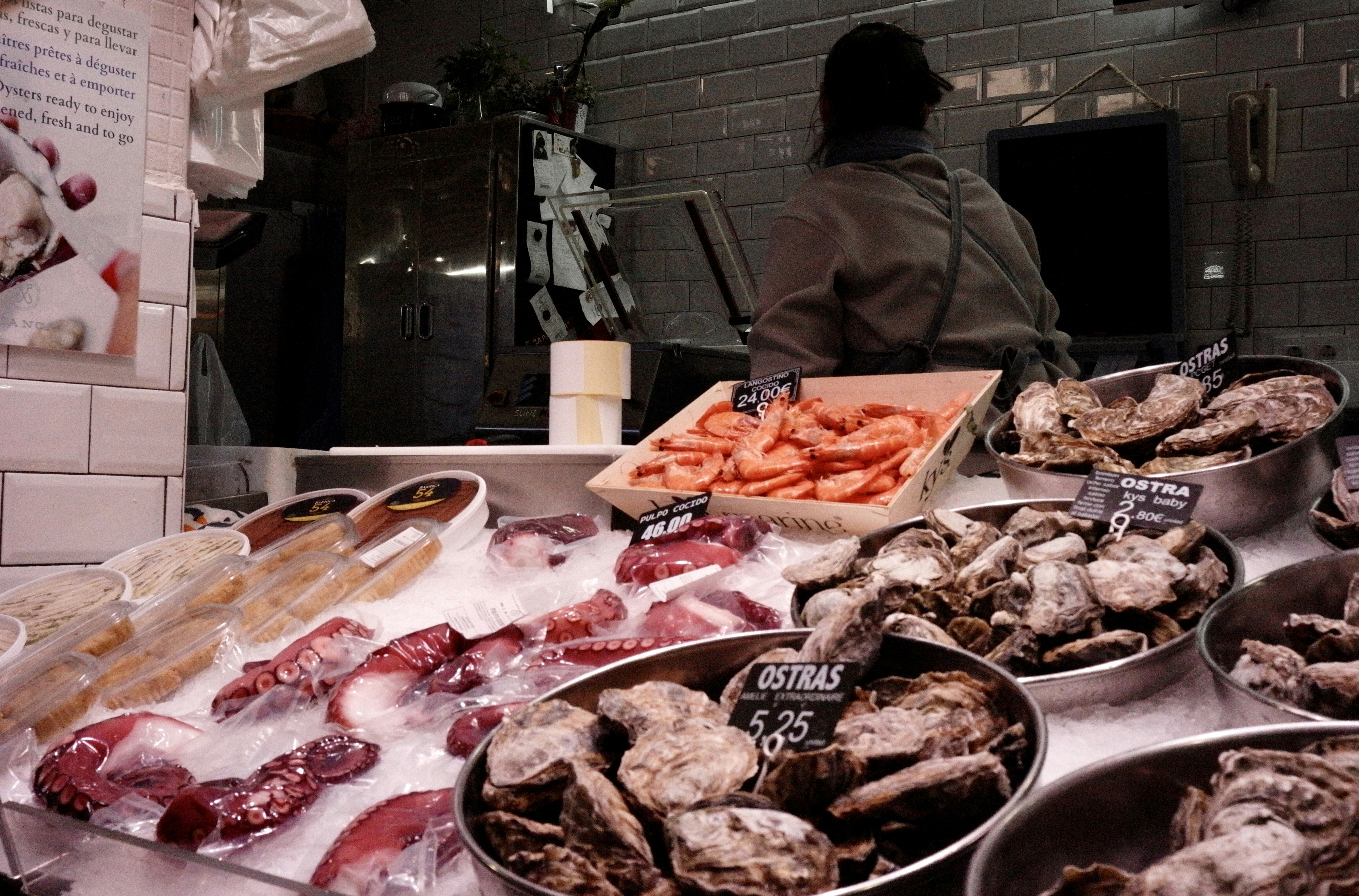 Market Display of Fresh Pastries and Seafood with a Backward-Facing Shopper