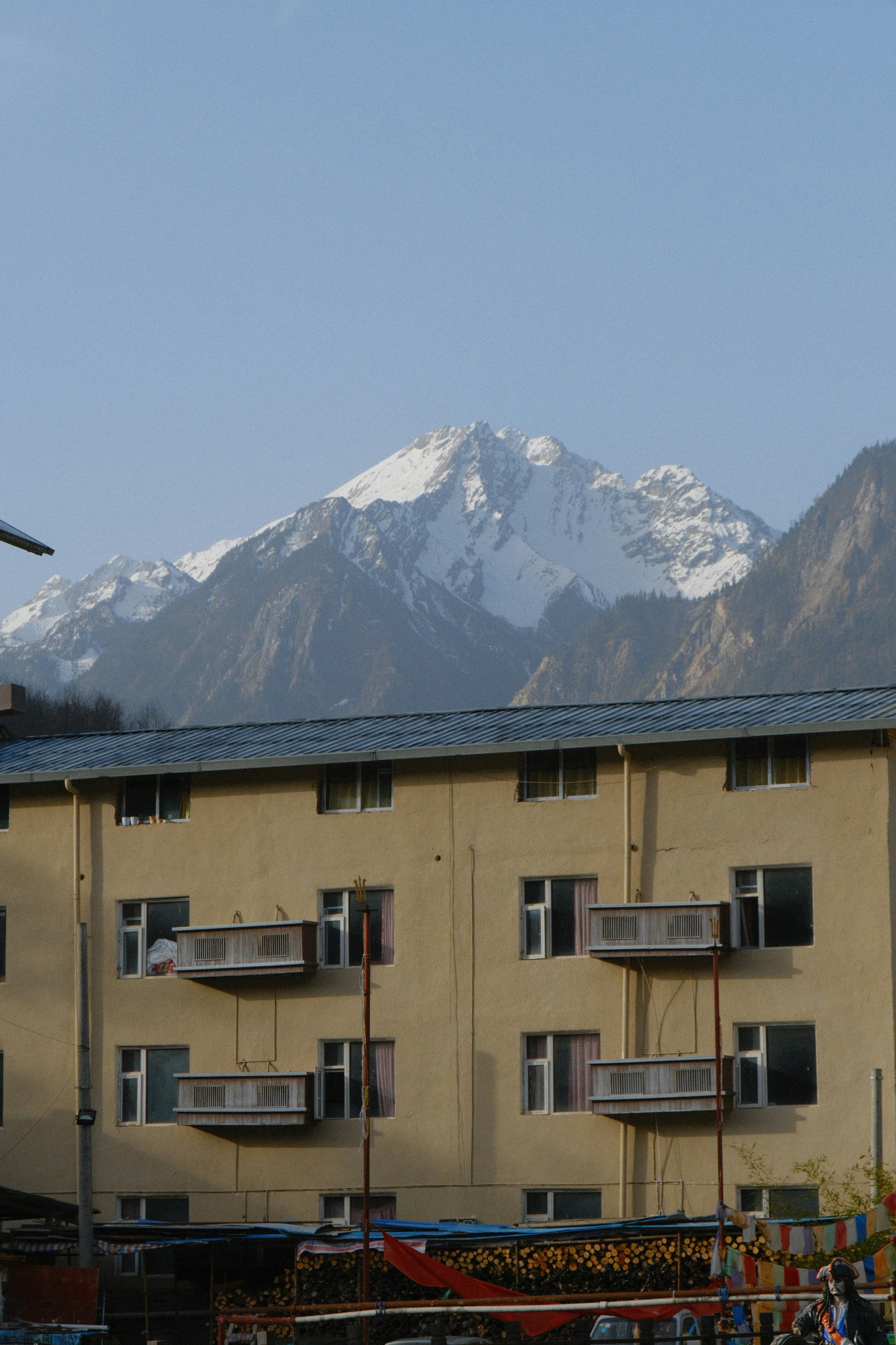 Snow-capped Peaks over a Beige Apartment Row