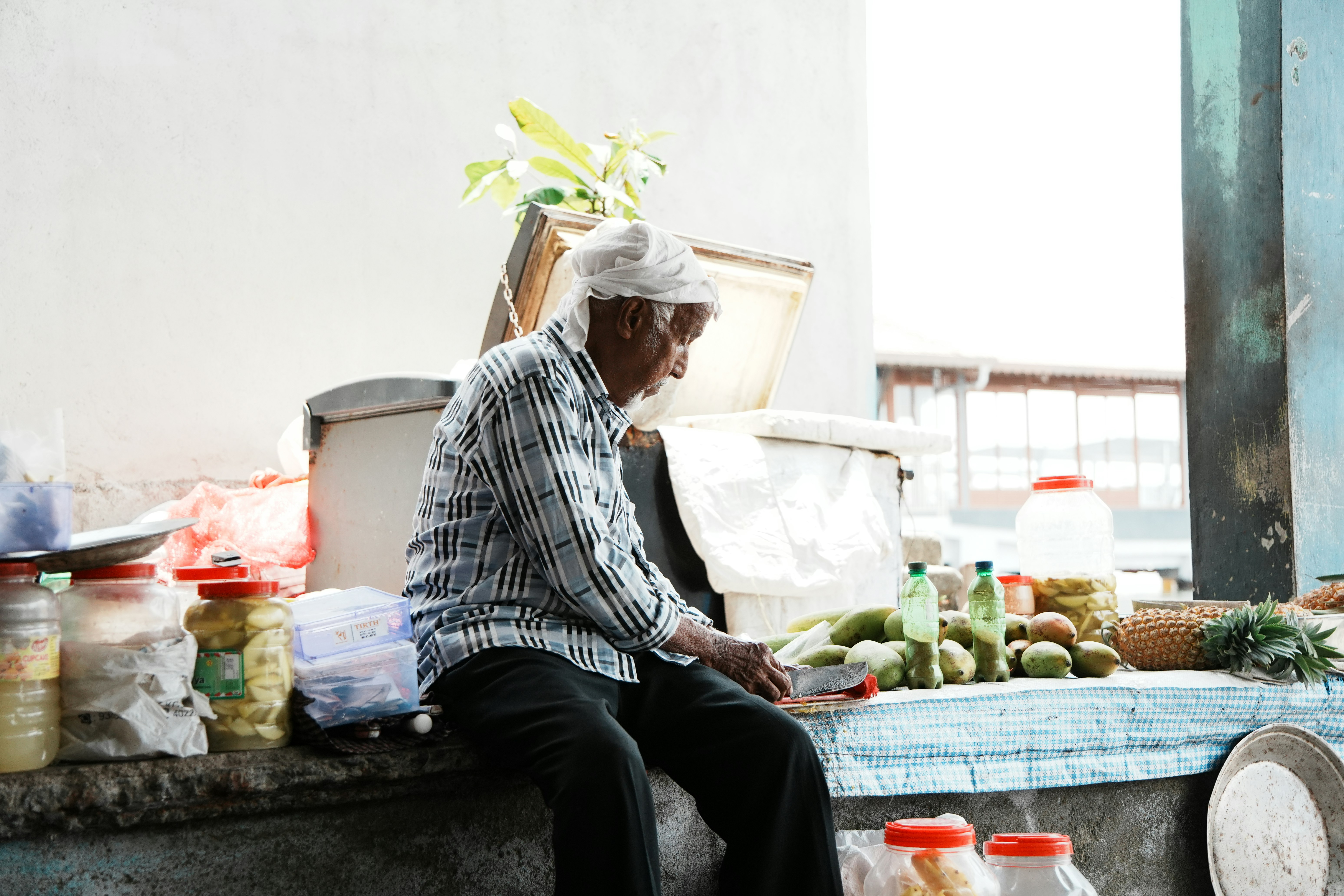 Seated Vendor in a Morning Market Stall