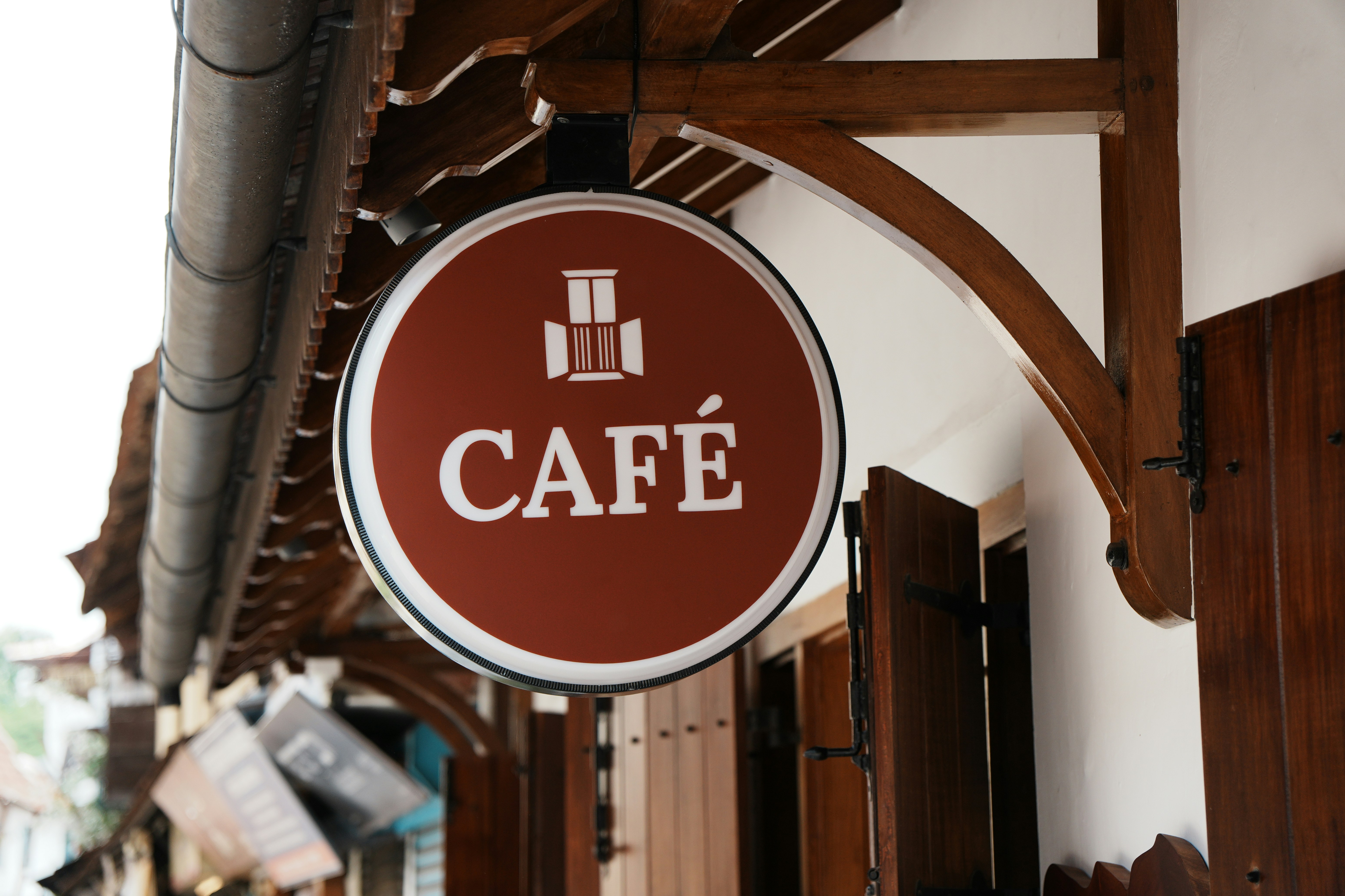 Round Café Sign in Classic Wooden Street Arcades