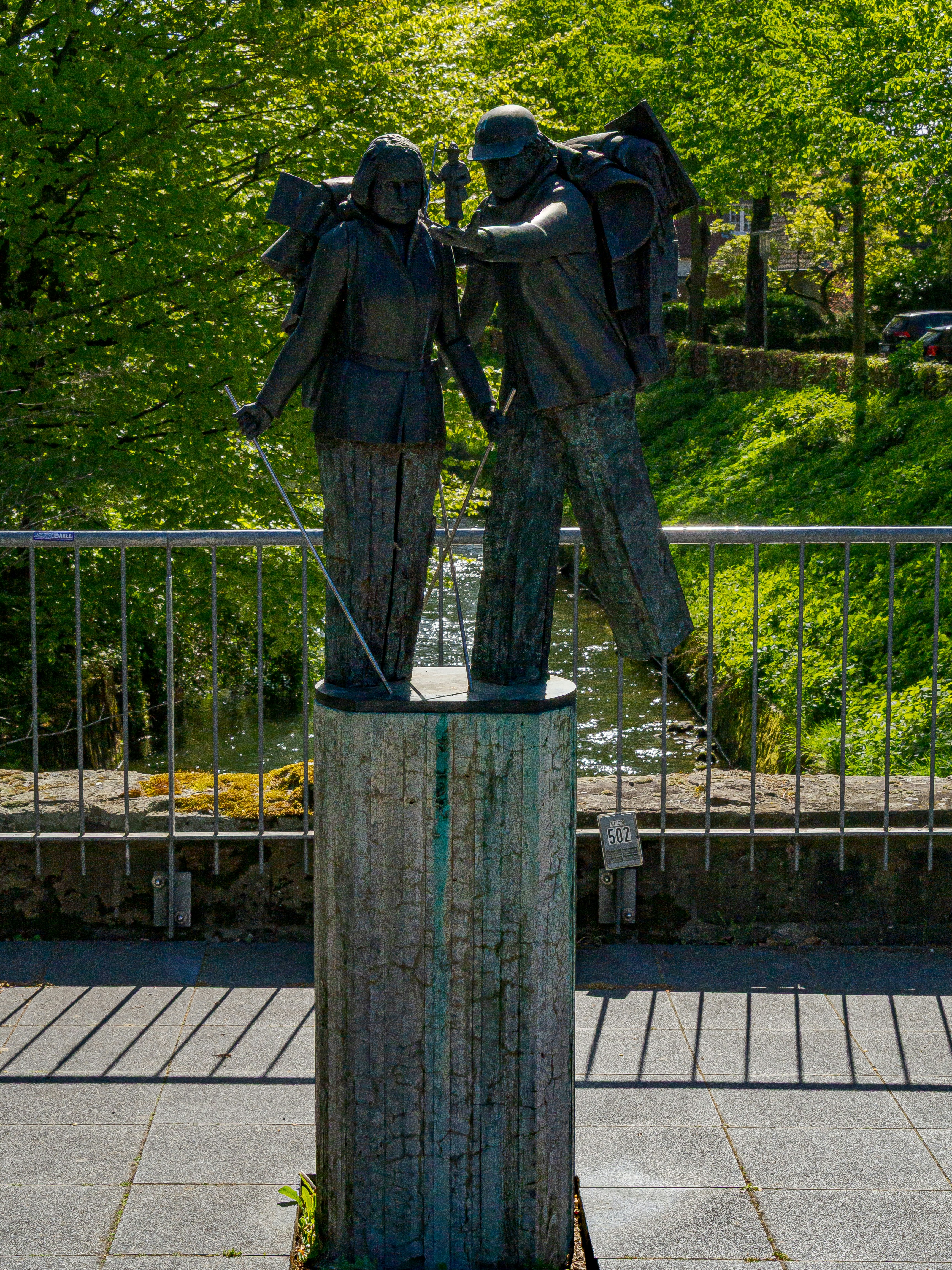Guardians of the Bridge: Bronze Figures Lean Toward Each Other