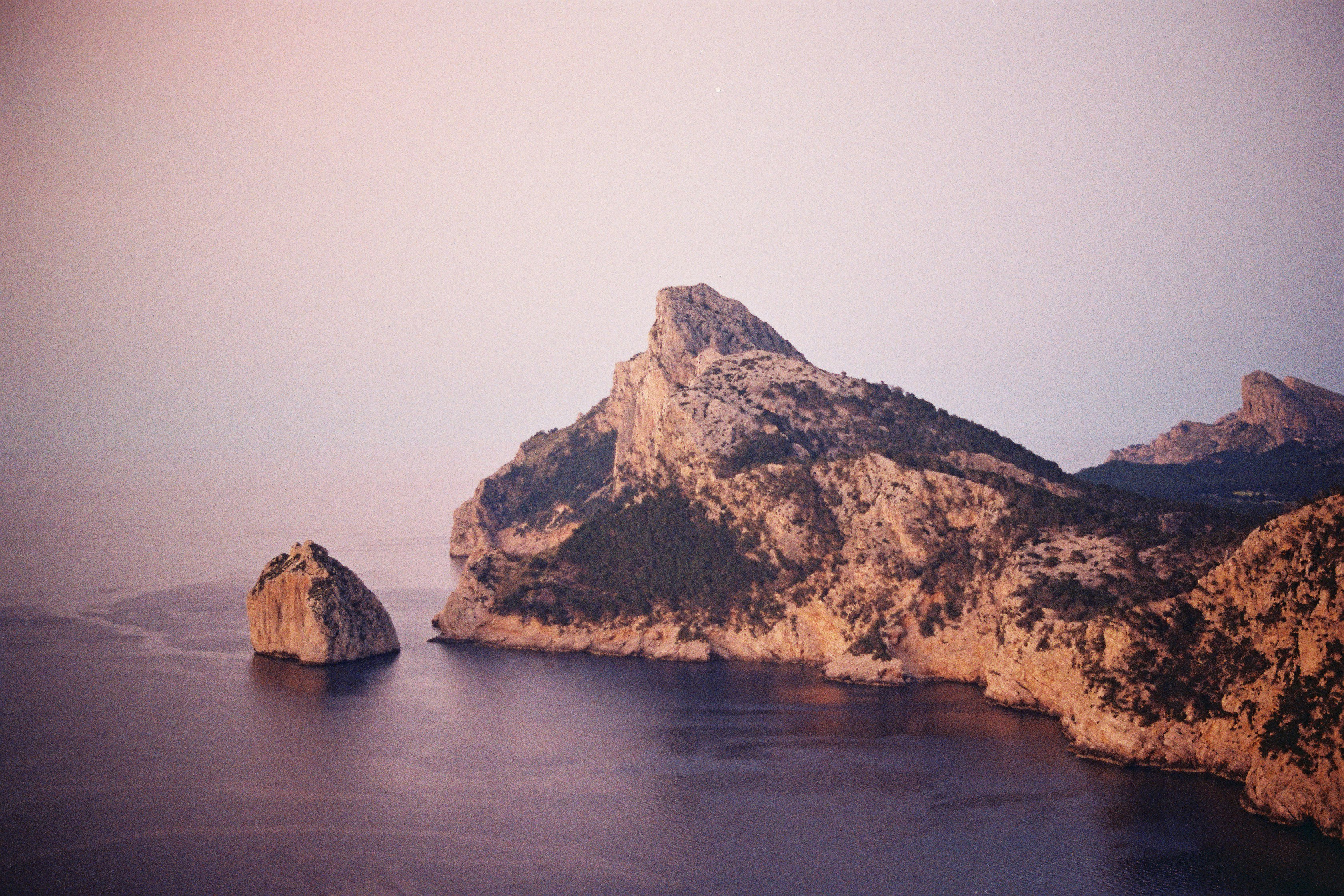 Coastal Promontory at Dusk: A Quiet Sea Embraces Rugged Cliffs