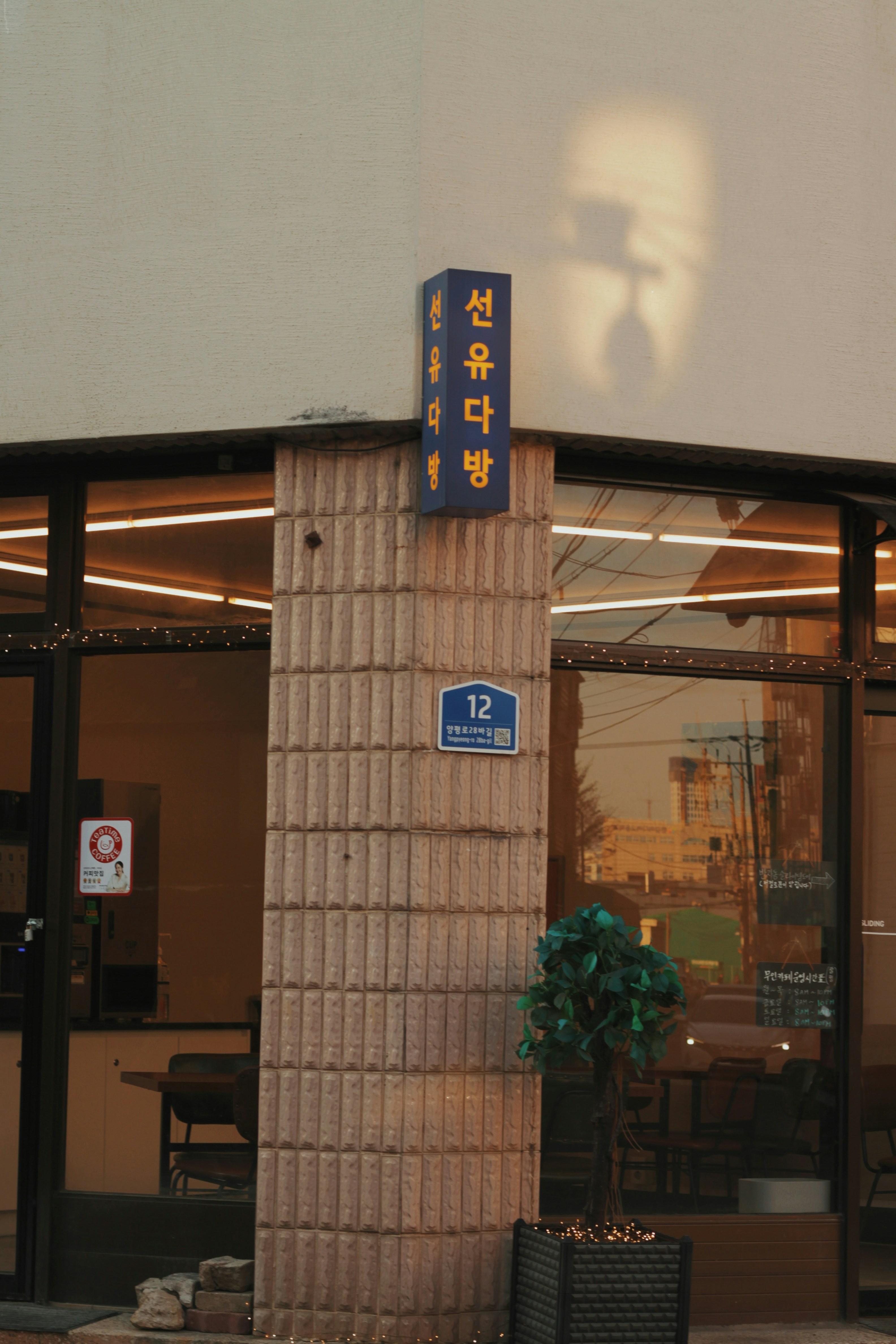 Street Corner Signage and Glass Reflections Between Pillars