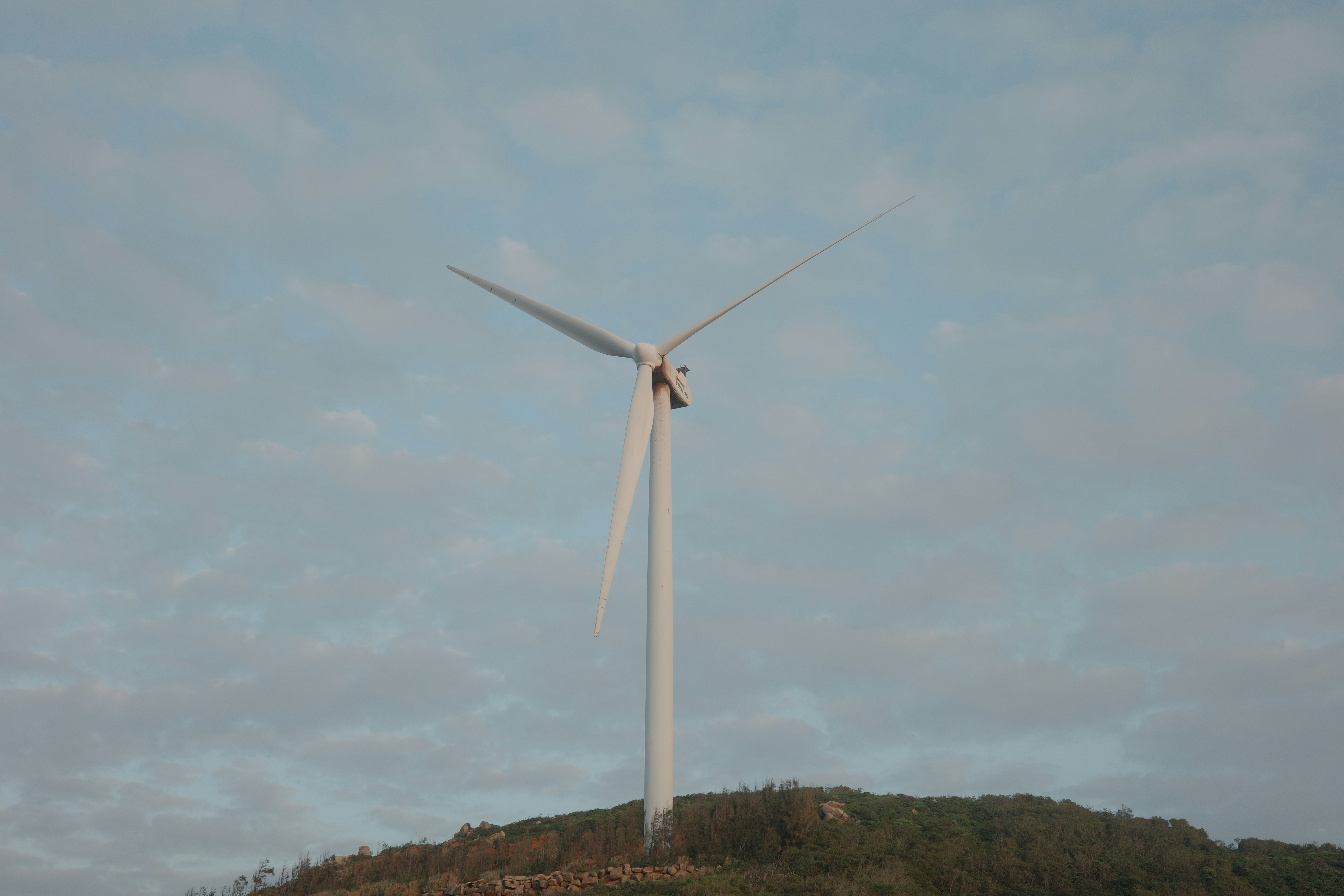 Windward Sentinel: A lone turbine crowned on a hill
