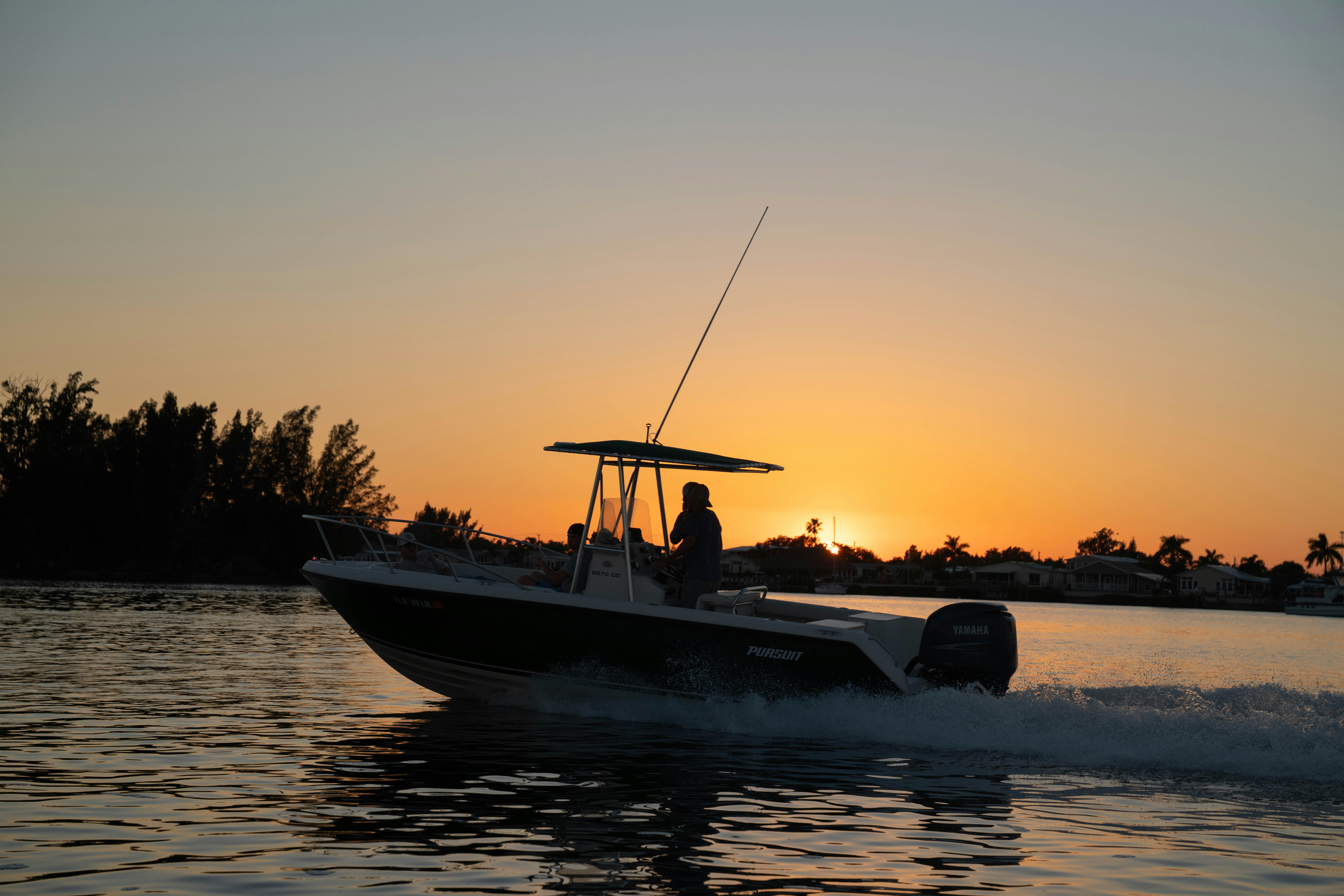 Sunset Pursuit: Boat Silhouette Cruising the Quiet Horizon
