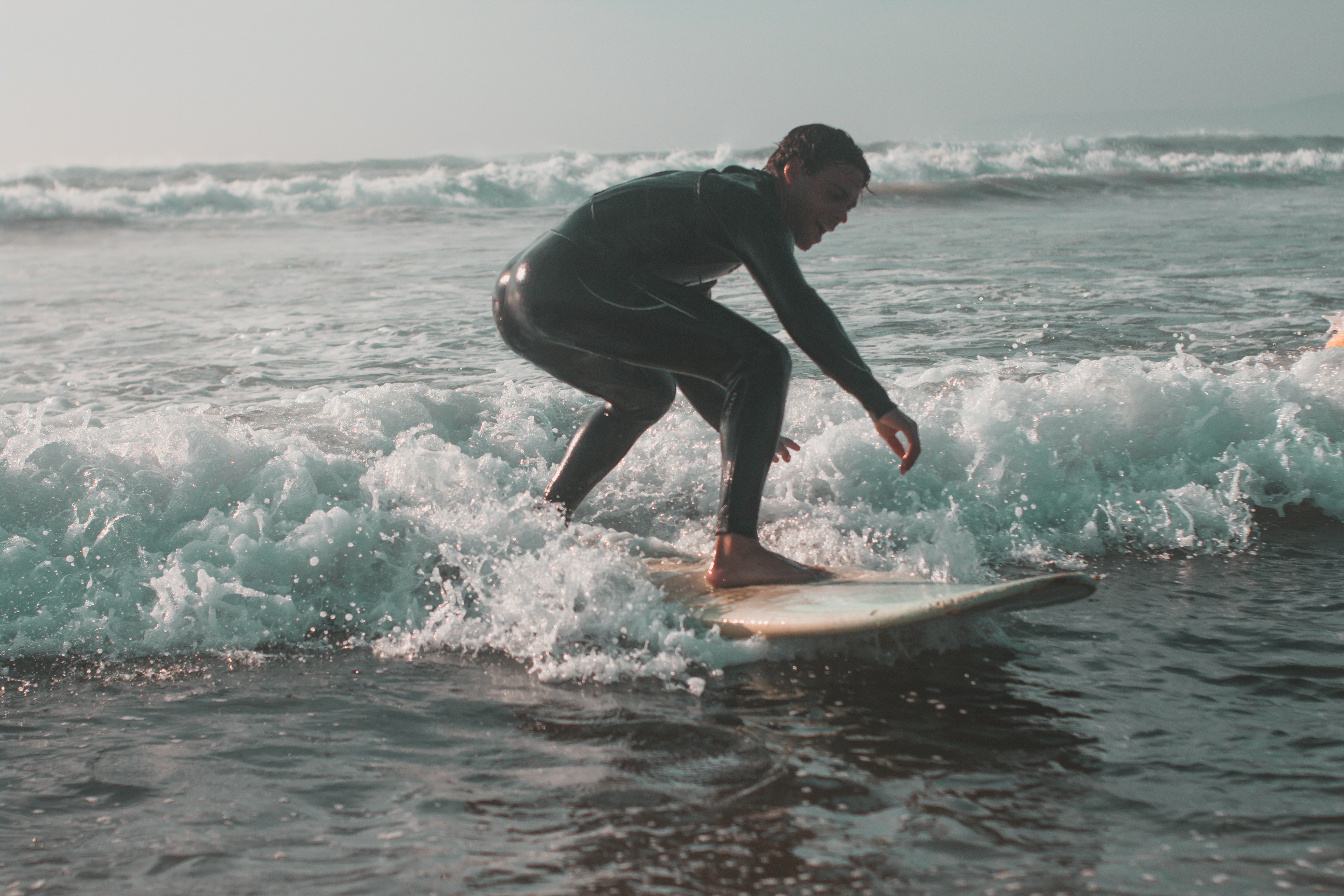 Surfer in a Cobalt Crest: a Wave Rider Glides along a Glassy Shore