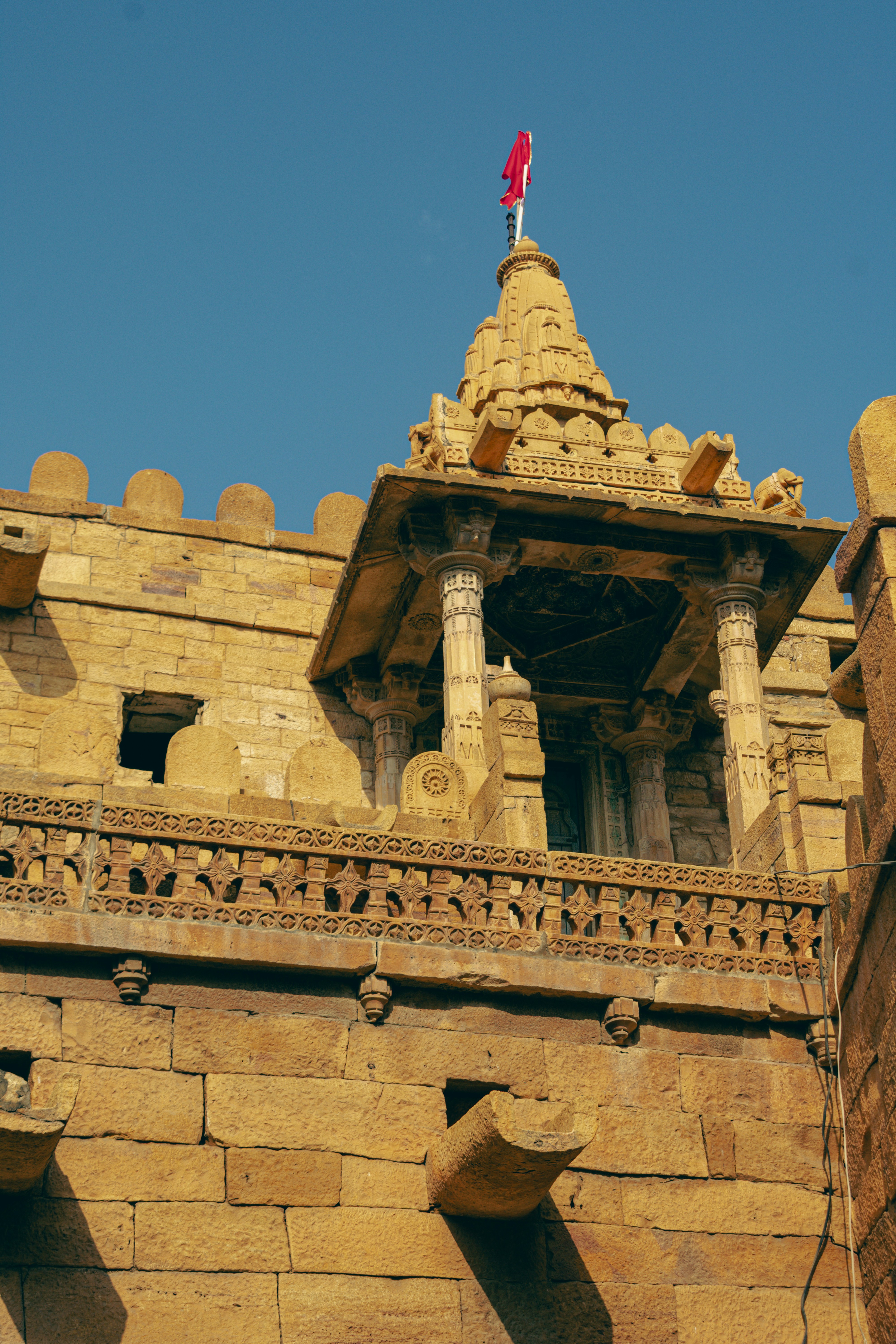 Sunlit Mandir Cantilever: A Corner of Ancient Fort Architecture under a Clear Sky