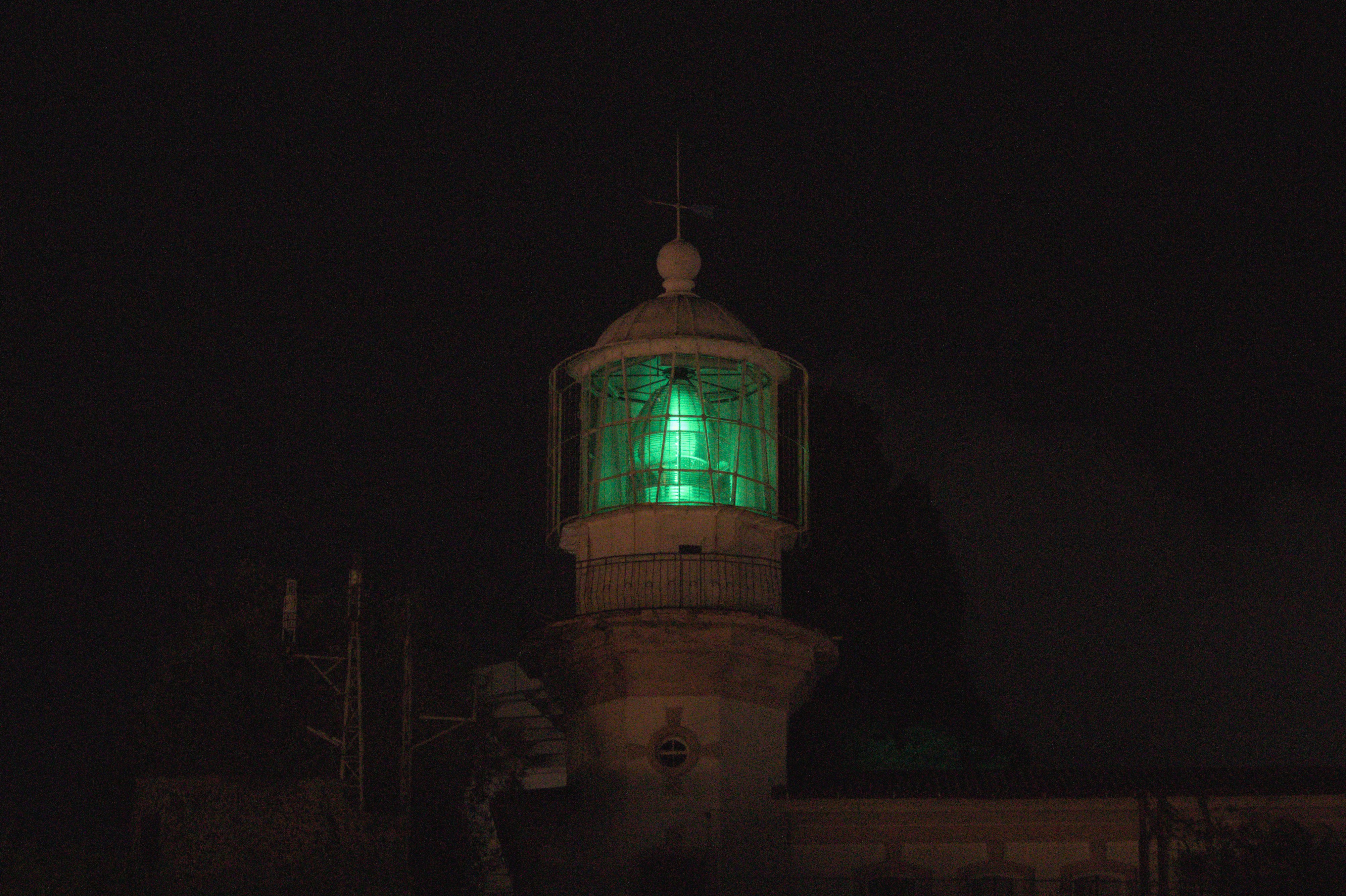 Green Beacon Afloat in the Night: Lighthouse Lantern in the Dark