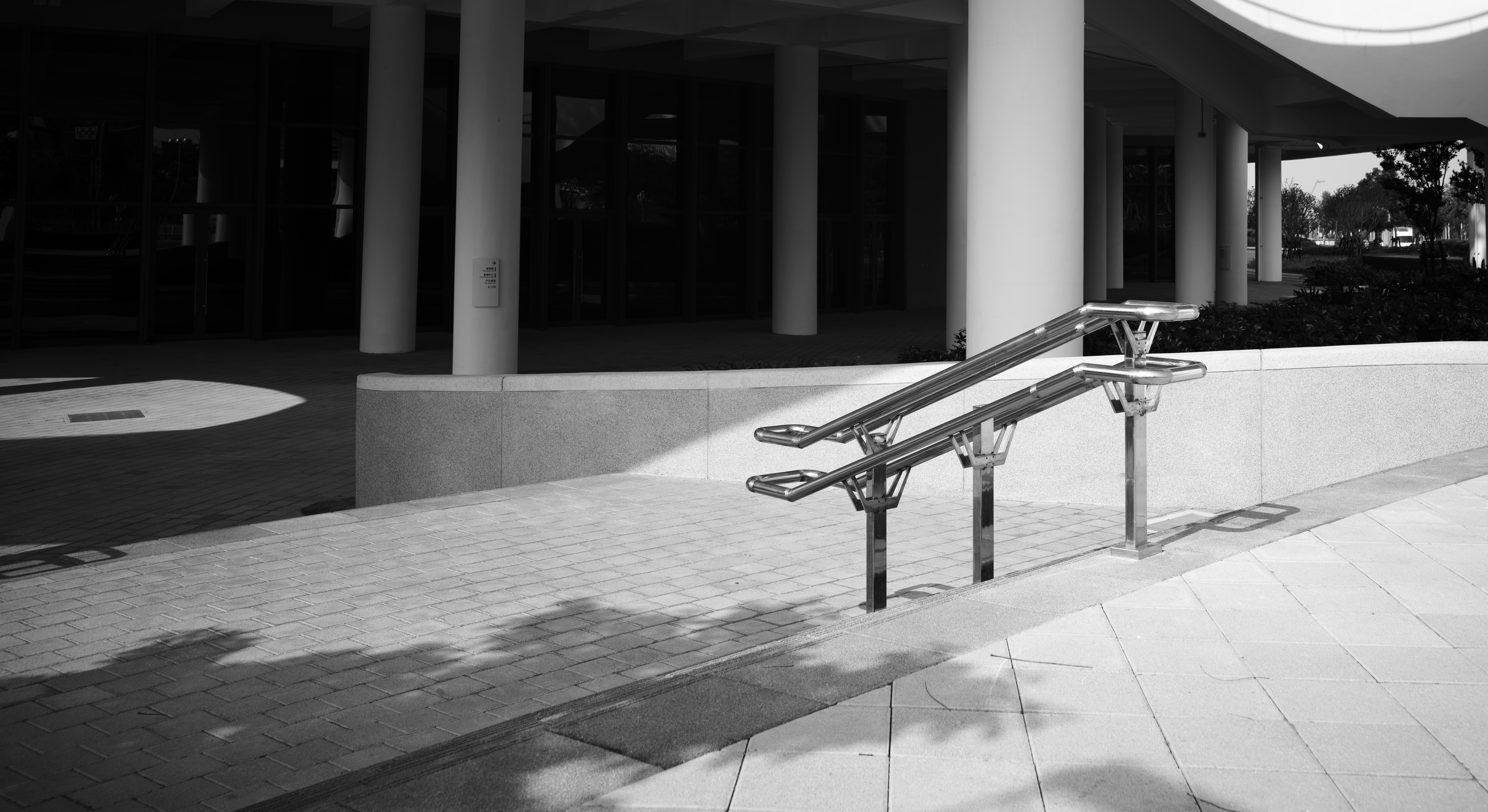 Silent Corridor: A Sunlit Railing Above Quiet Tiles